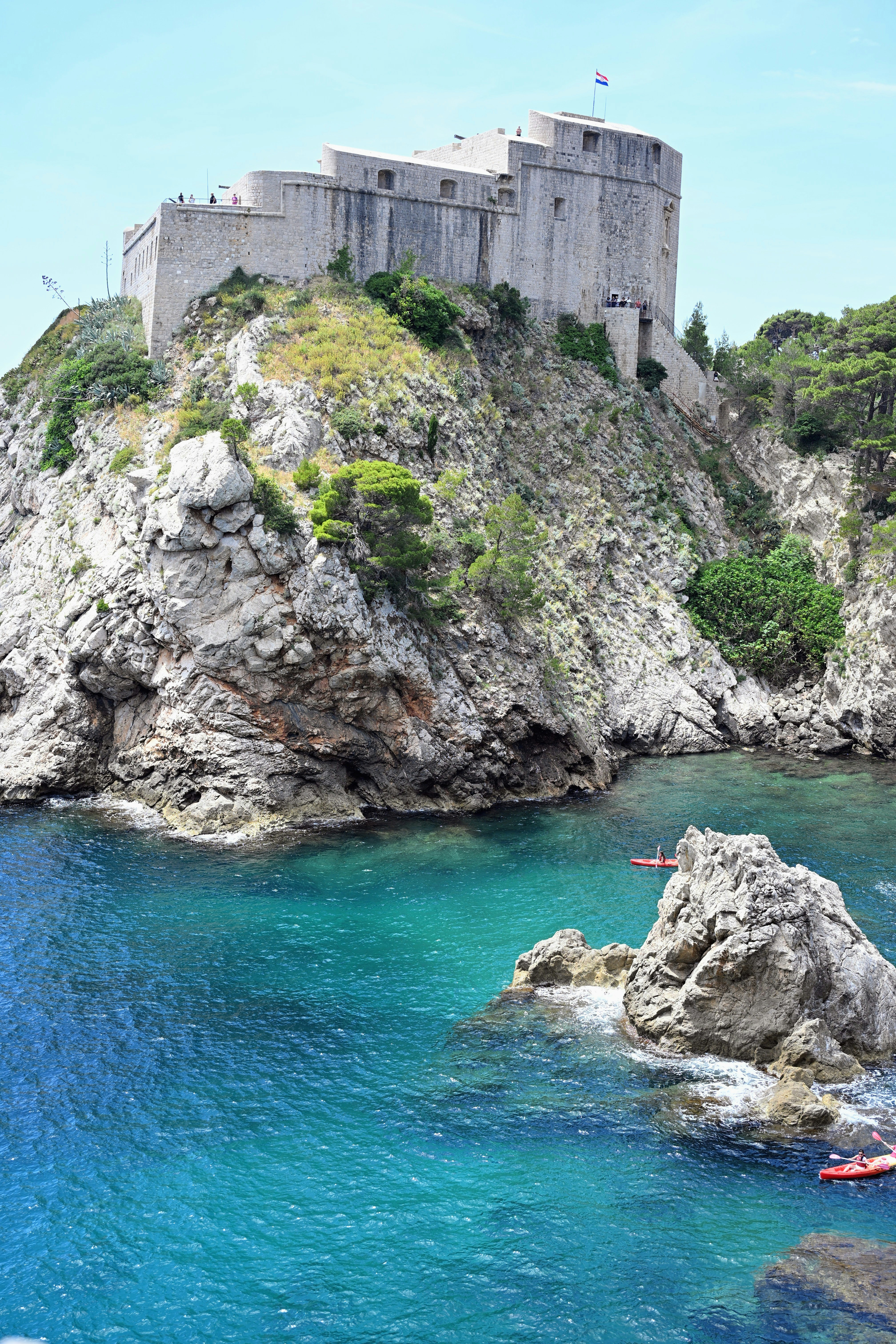 Castle on the Cliff: Sunlit fortress above turquoise seas