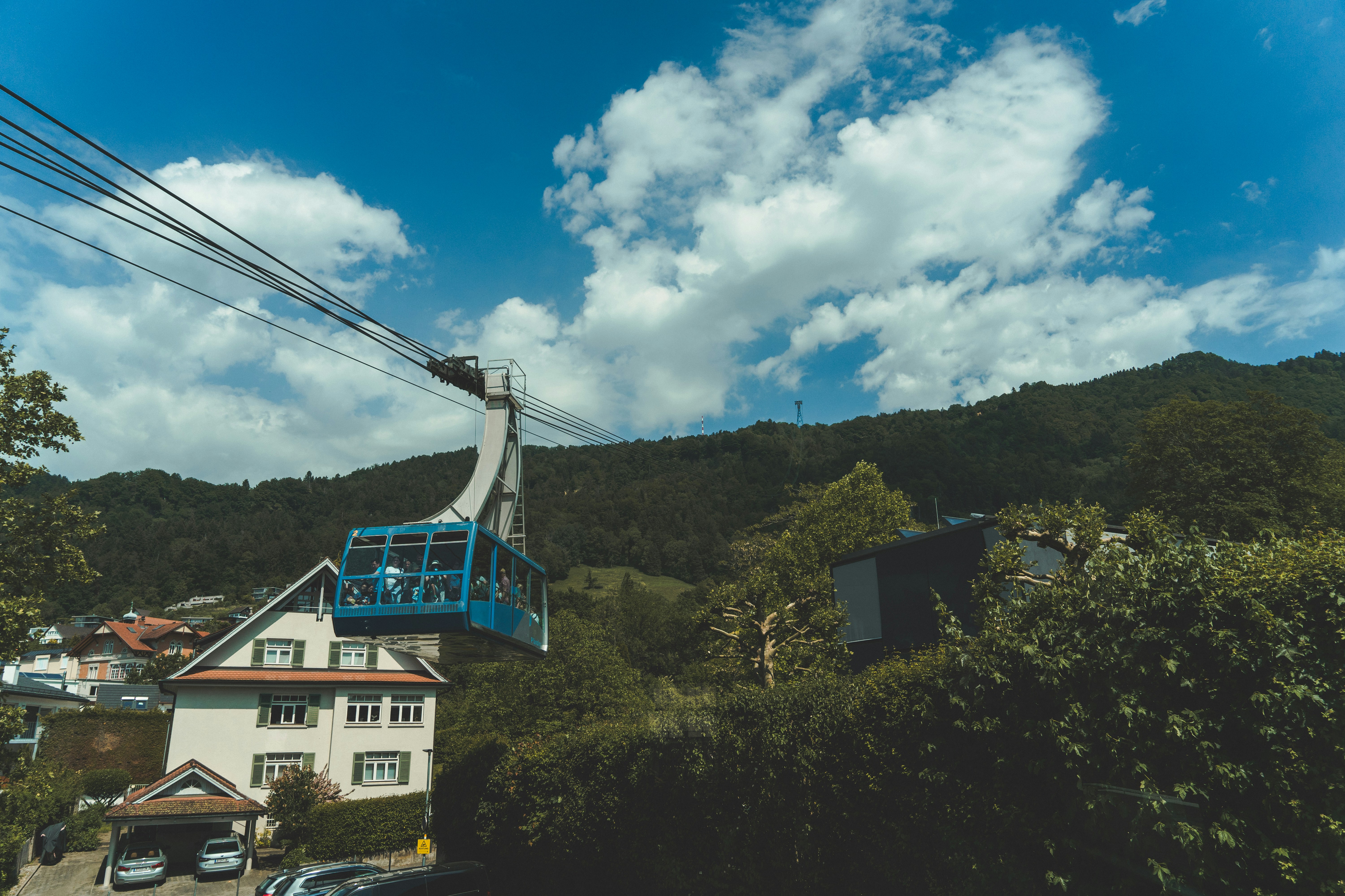 Blue Cable Car Soaring Over a Quaint hillside Village