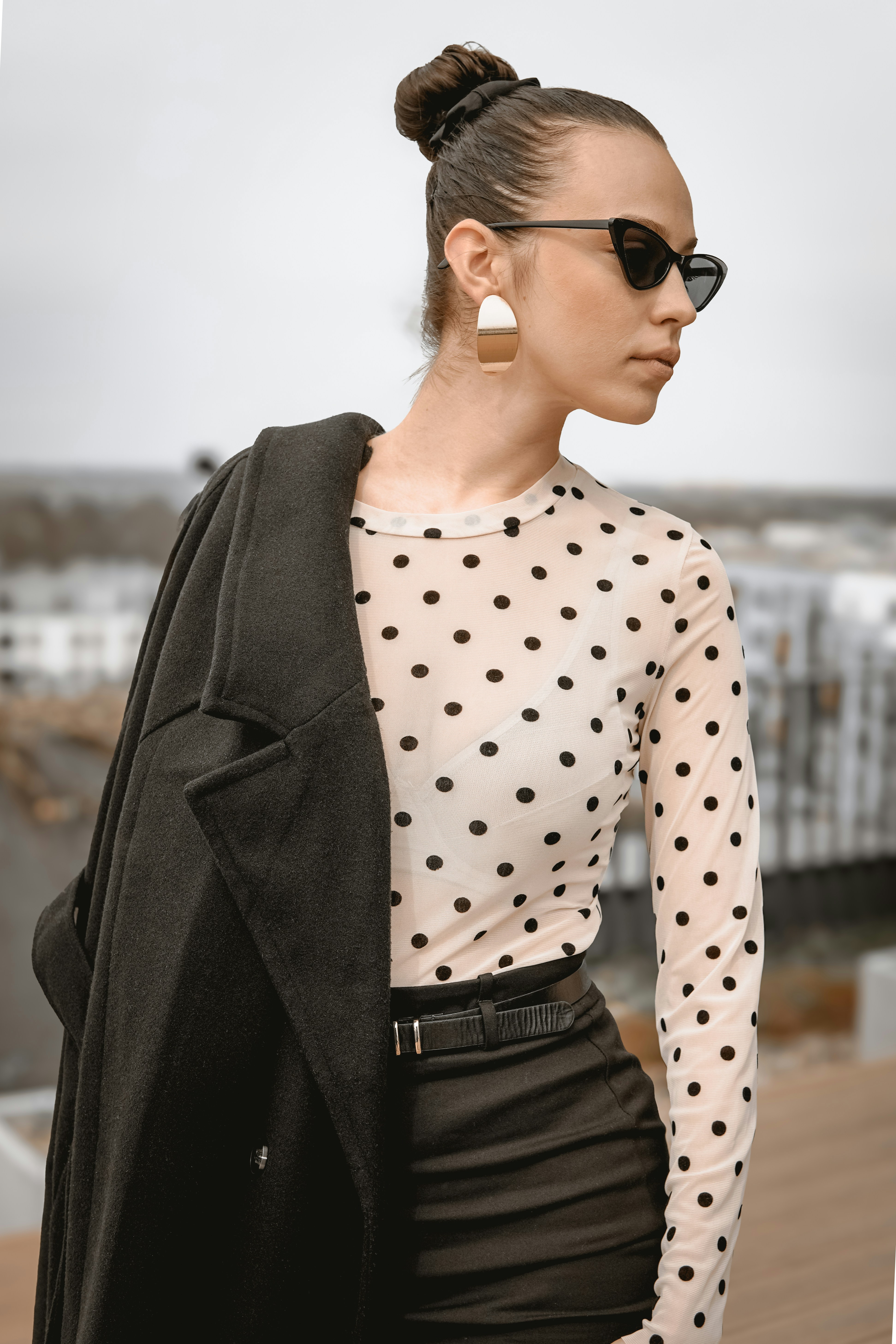 Stylish woman in polka dot top and sunglasses.