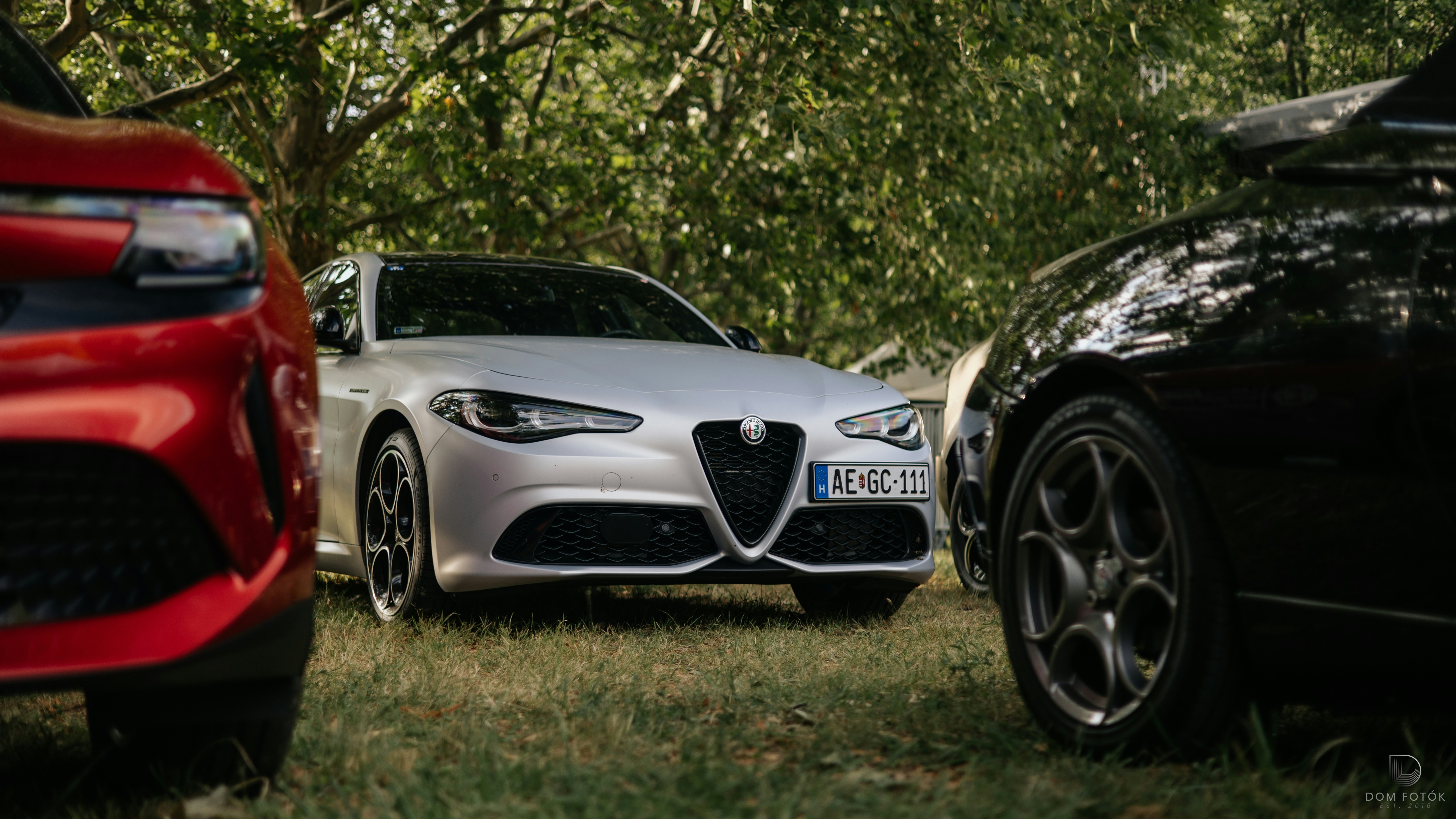 Central Alfa Romeo Emergence: White sedan framed by surrounding cars