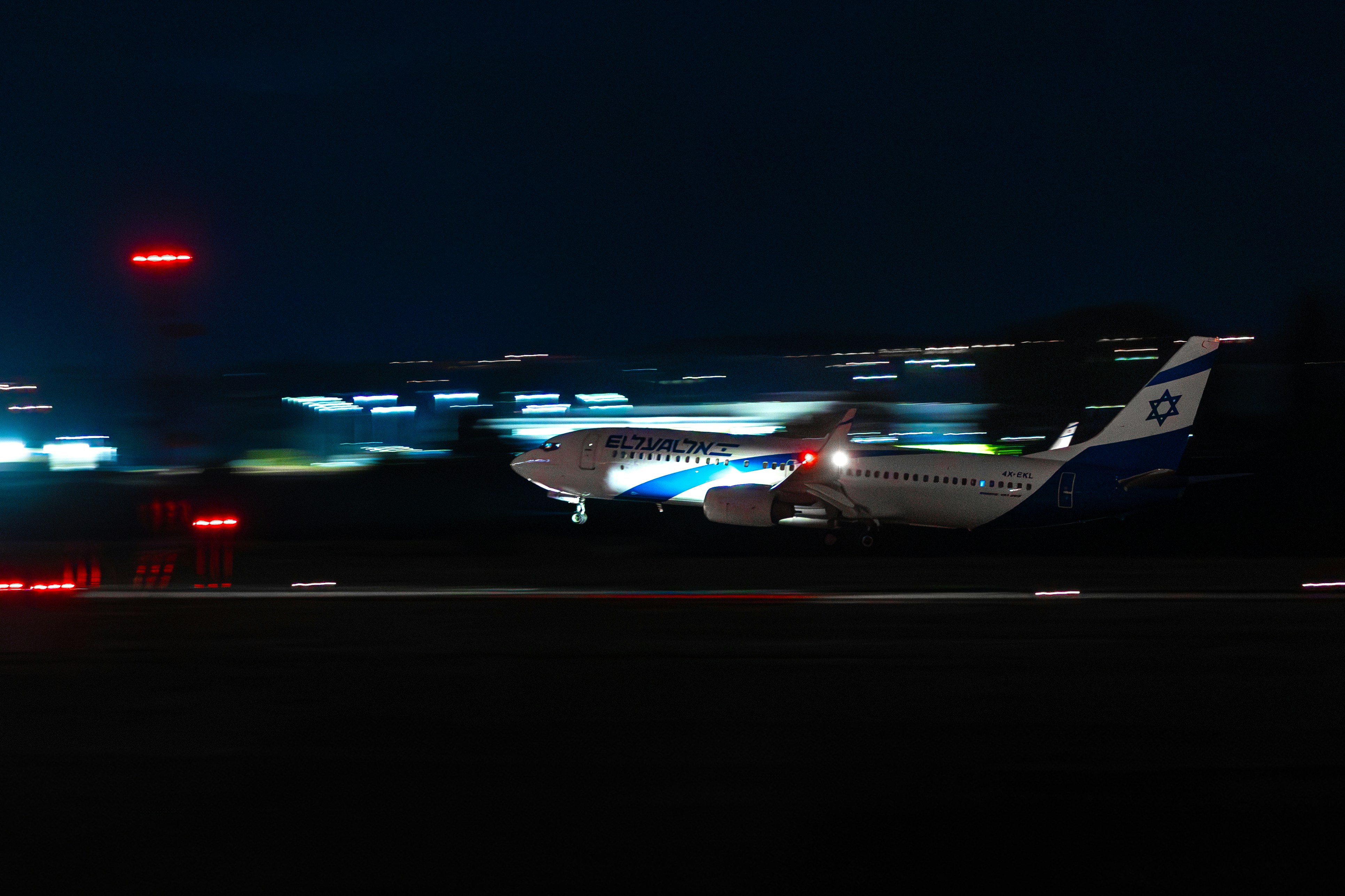 Night Takeoff: Glowing Jet Amidst Blue Runway Lights
