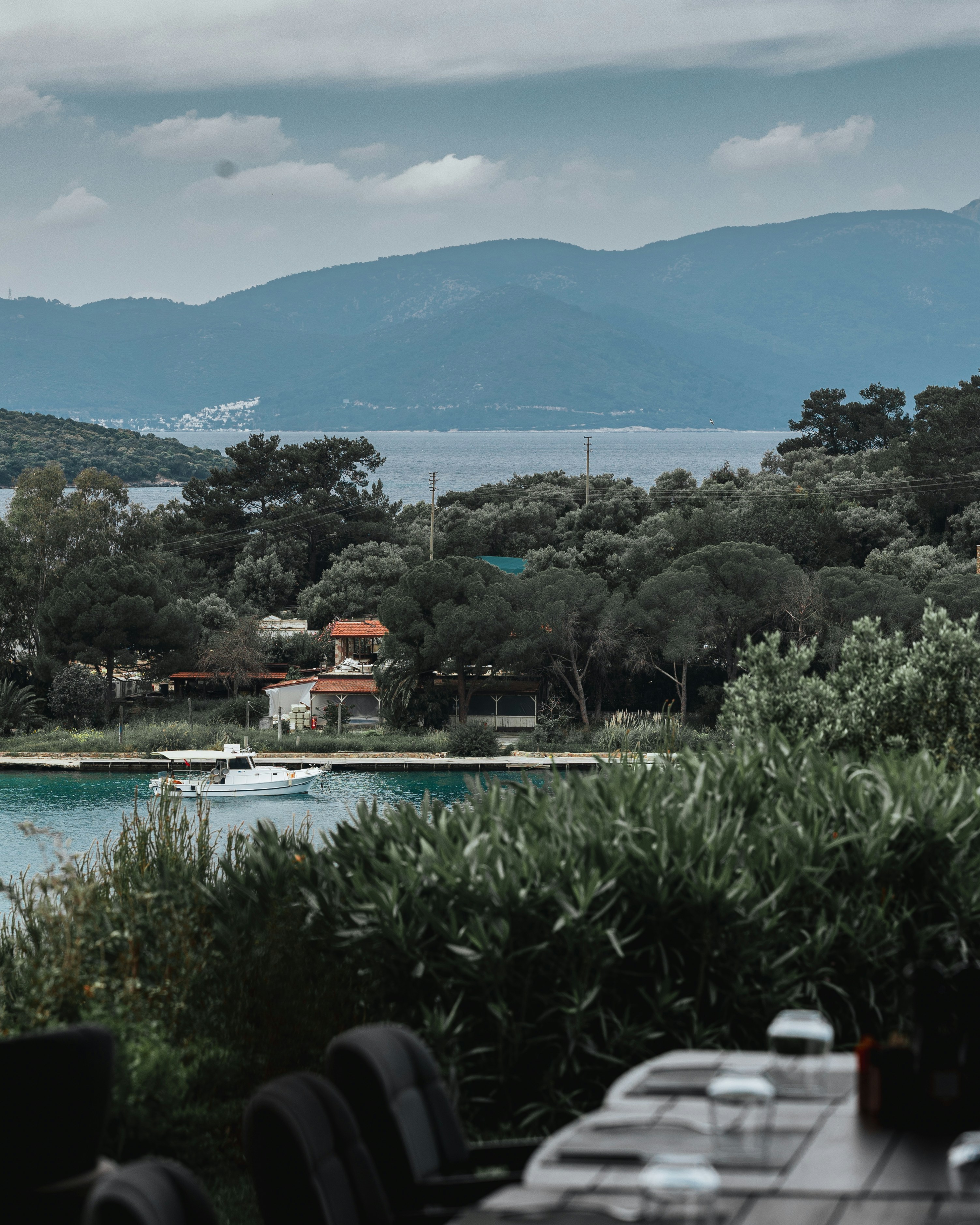 Lakeside Village framed by pine silhouettes and distant hills