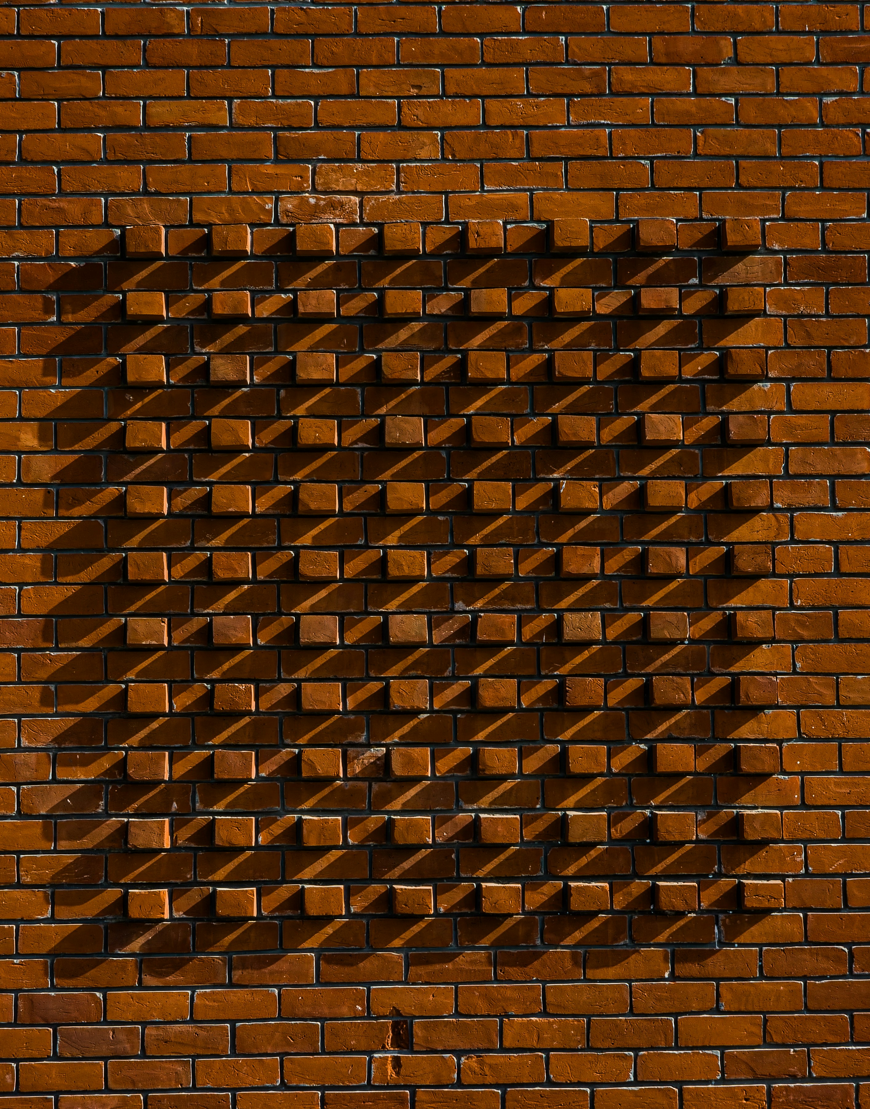 Brick Shadow Palette: A Framed Circular Pattern in Orange Facade