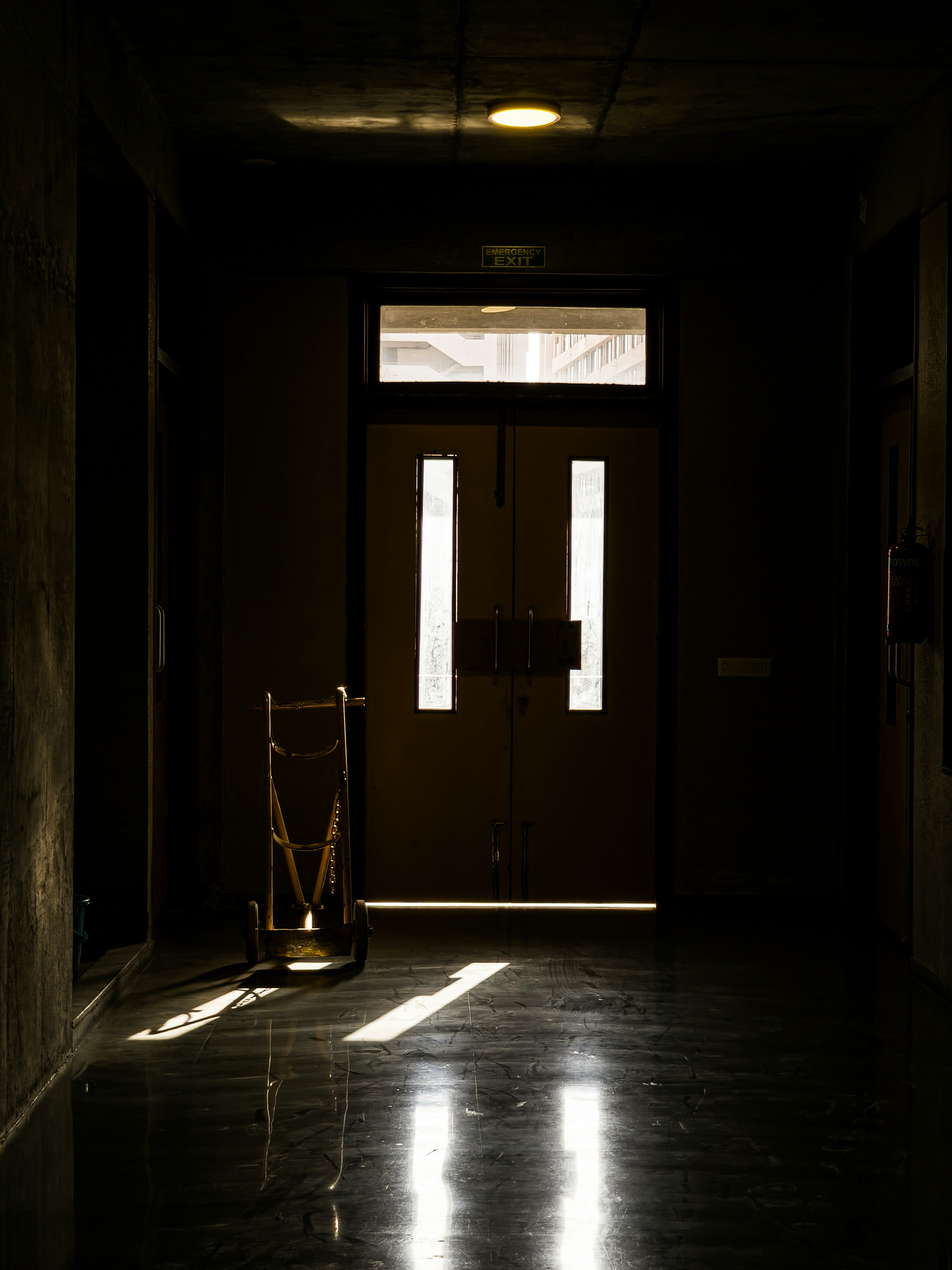 Backlit Exit: Quiet Corridor Leading to Light