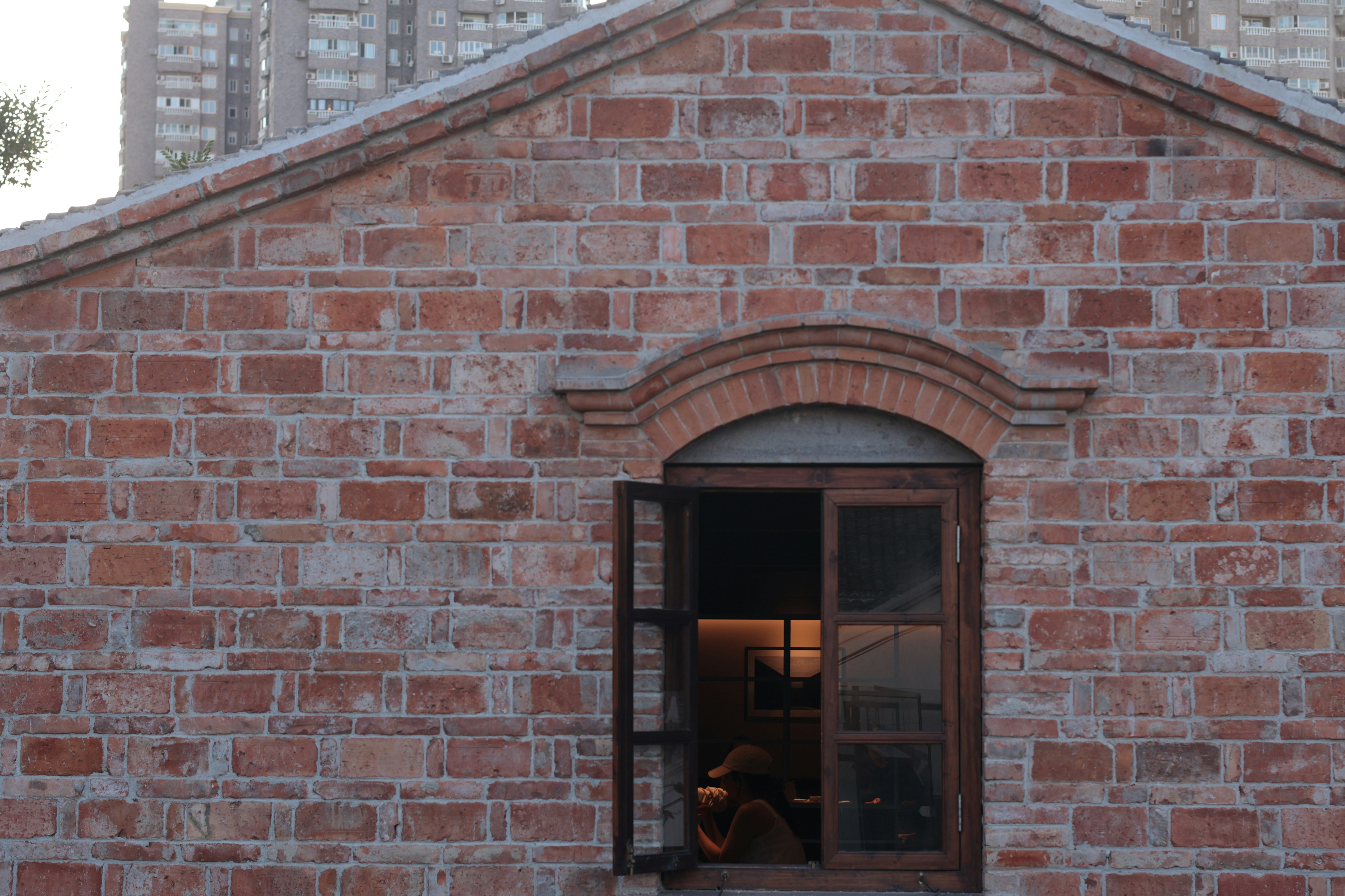 Open Window, Warm Interior on a Brick Roofline