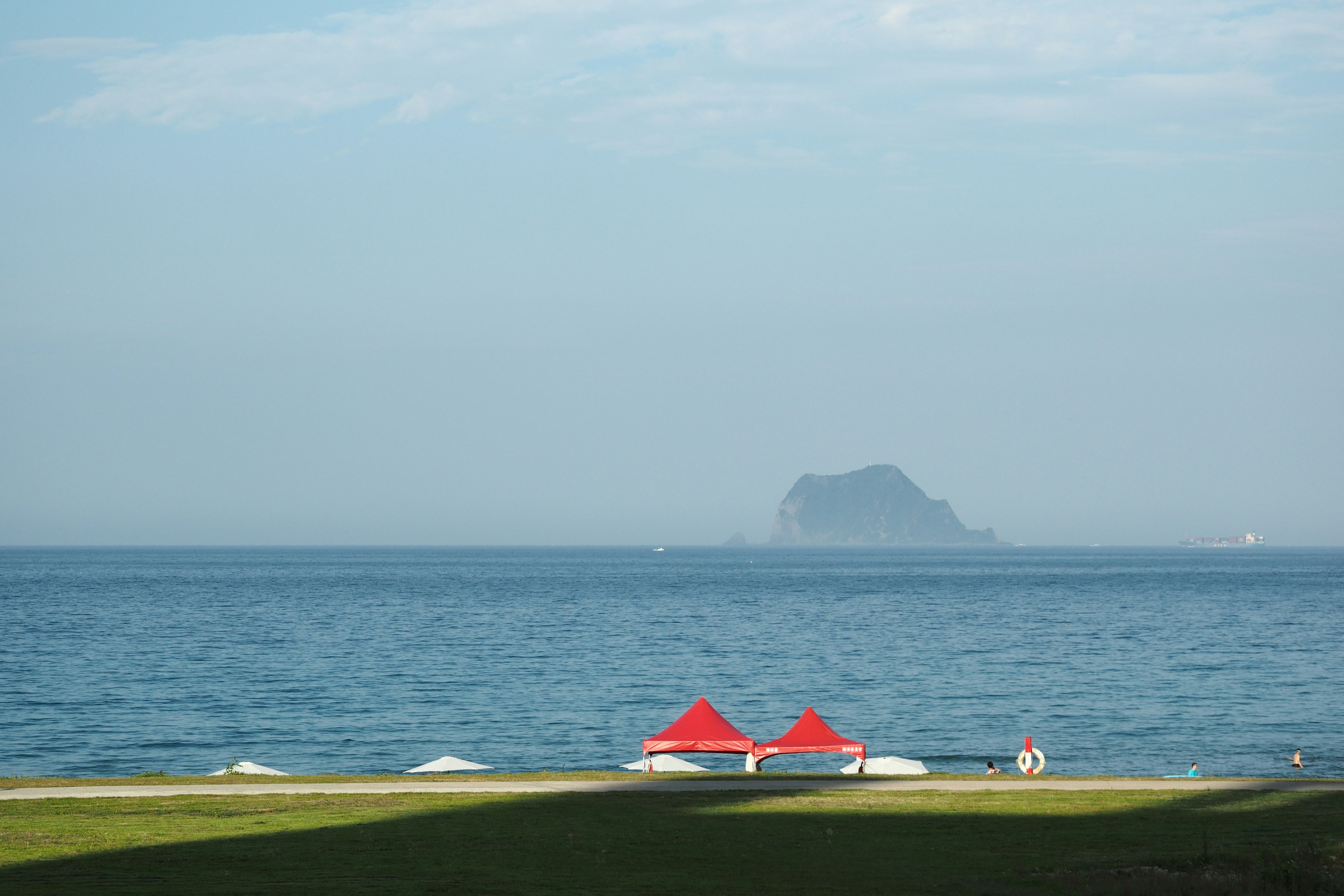 Sunny Beachside Canopy: Tents by the Quiet Sea