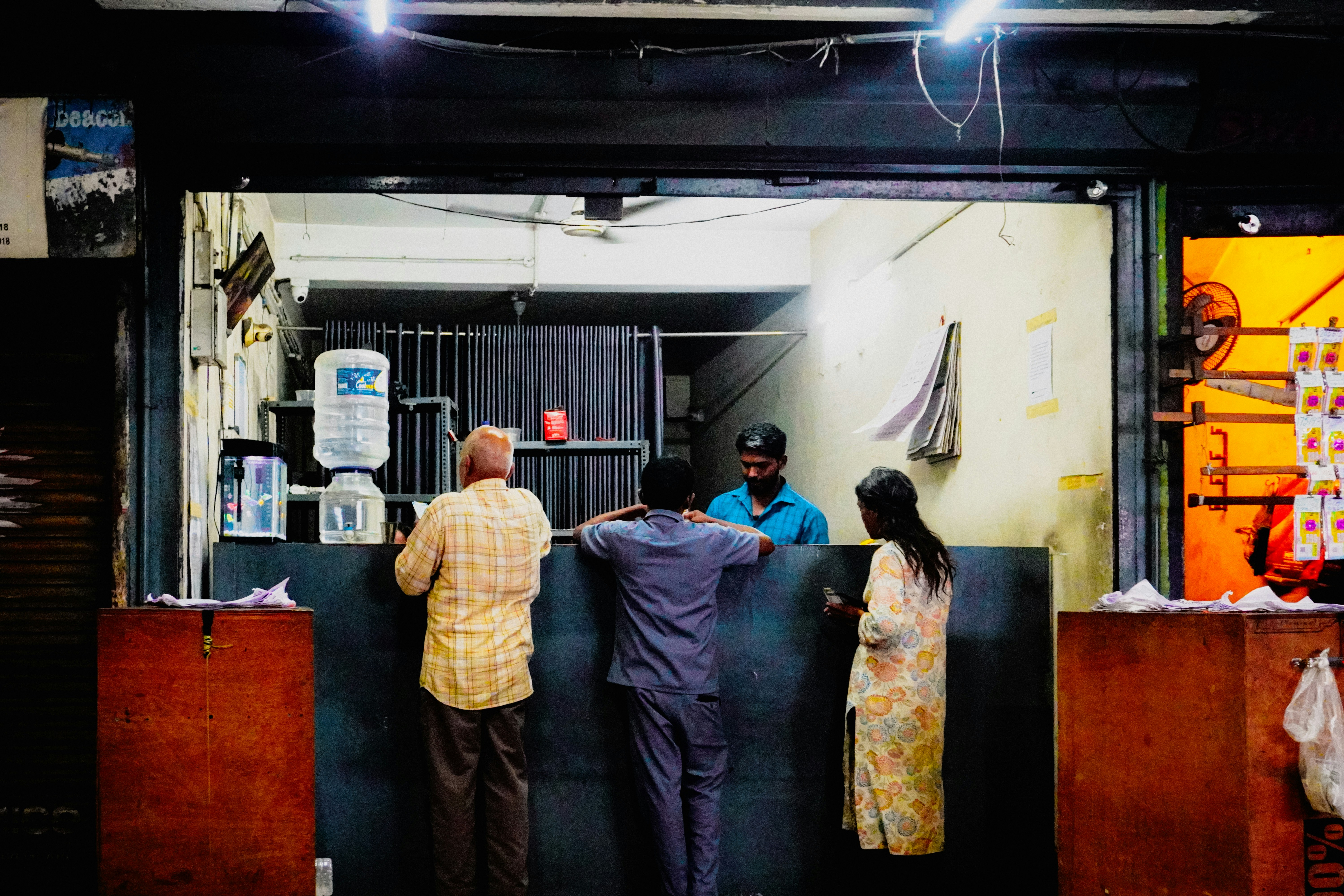 Customers interact with a vendor at a street shop.