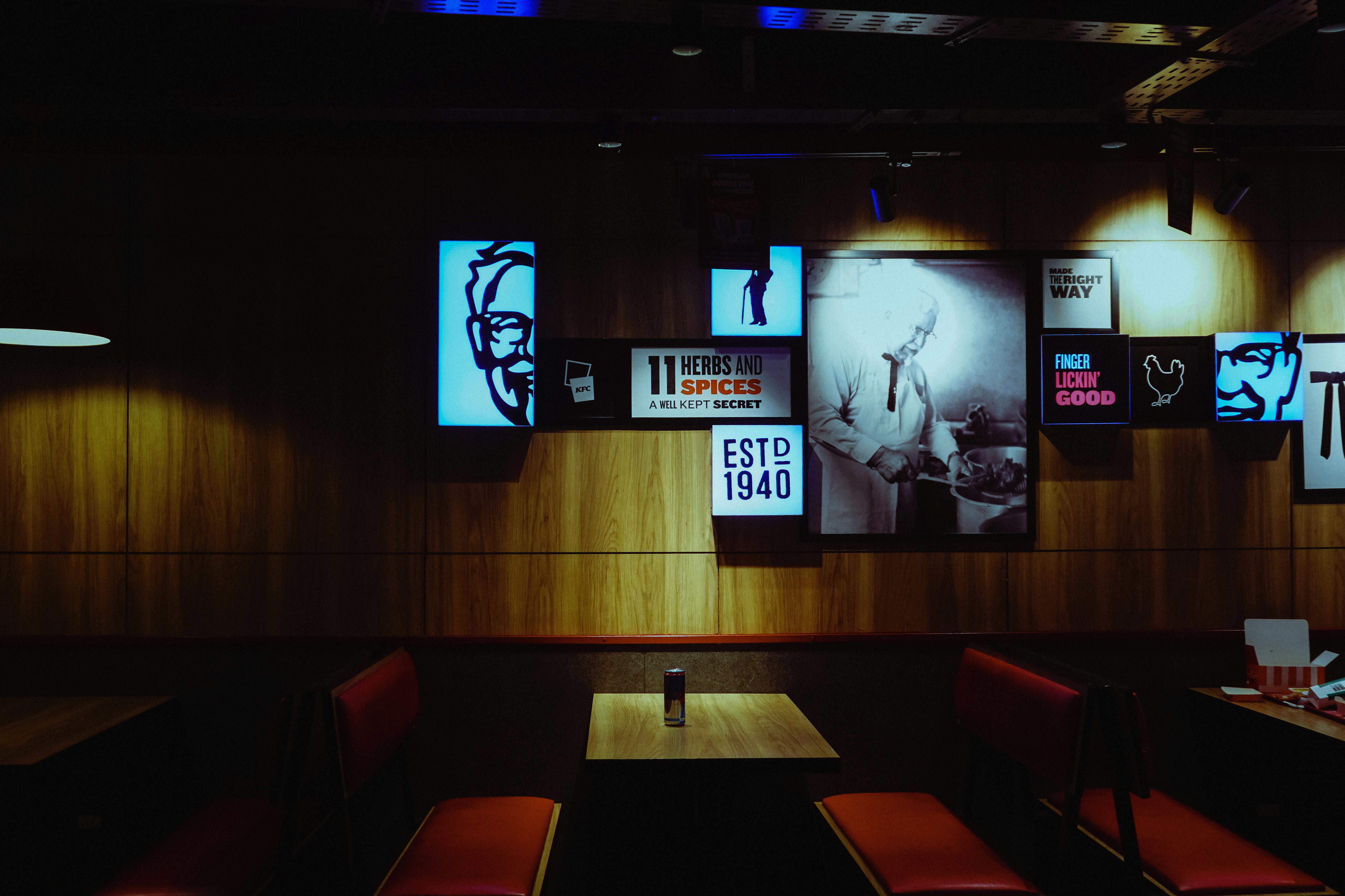 Kfc restaurant interior with booths and colonel sanders wall art.