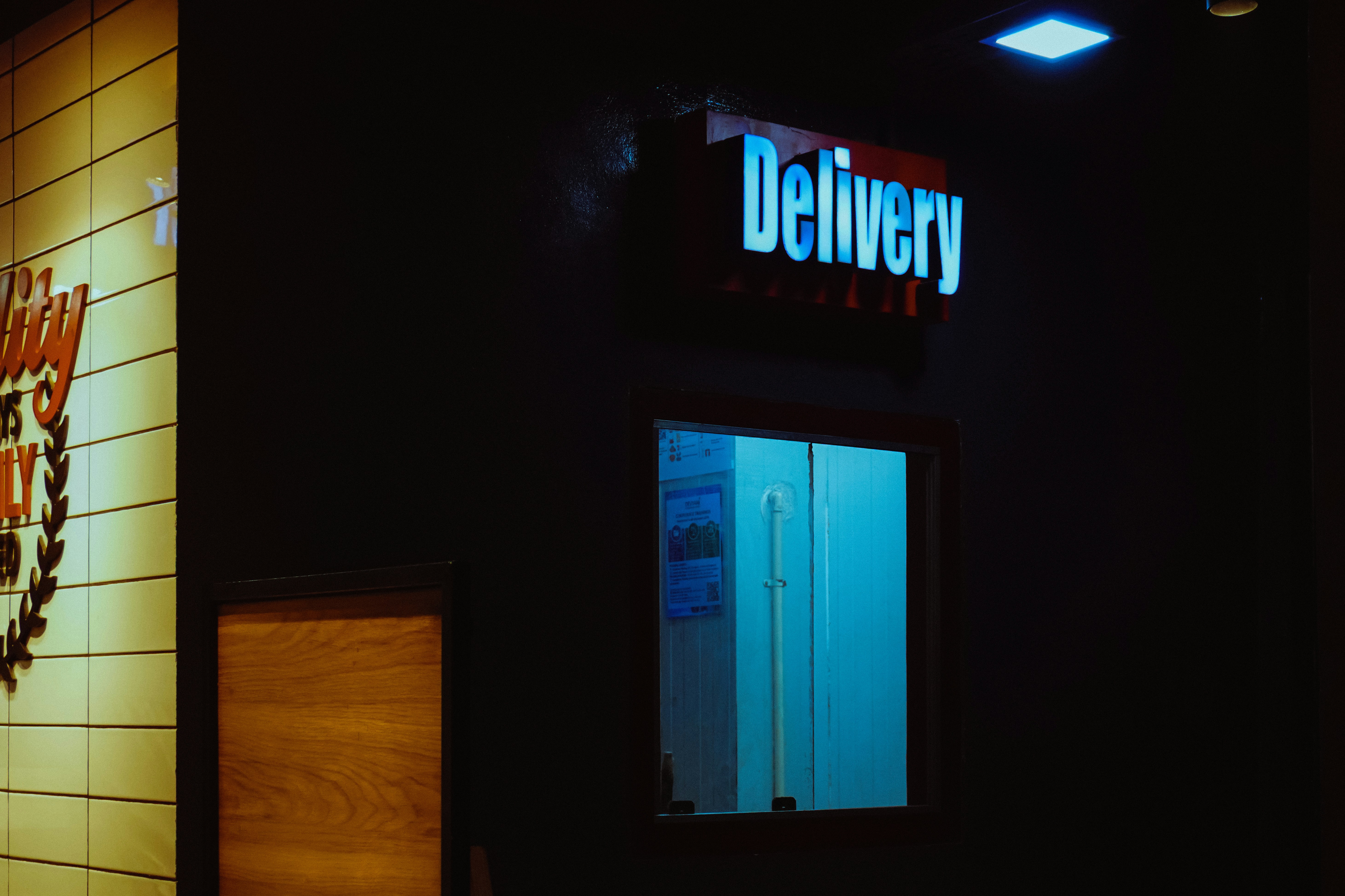 Neon Blue Window: A Quiet Delivery Entrance at Night