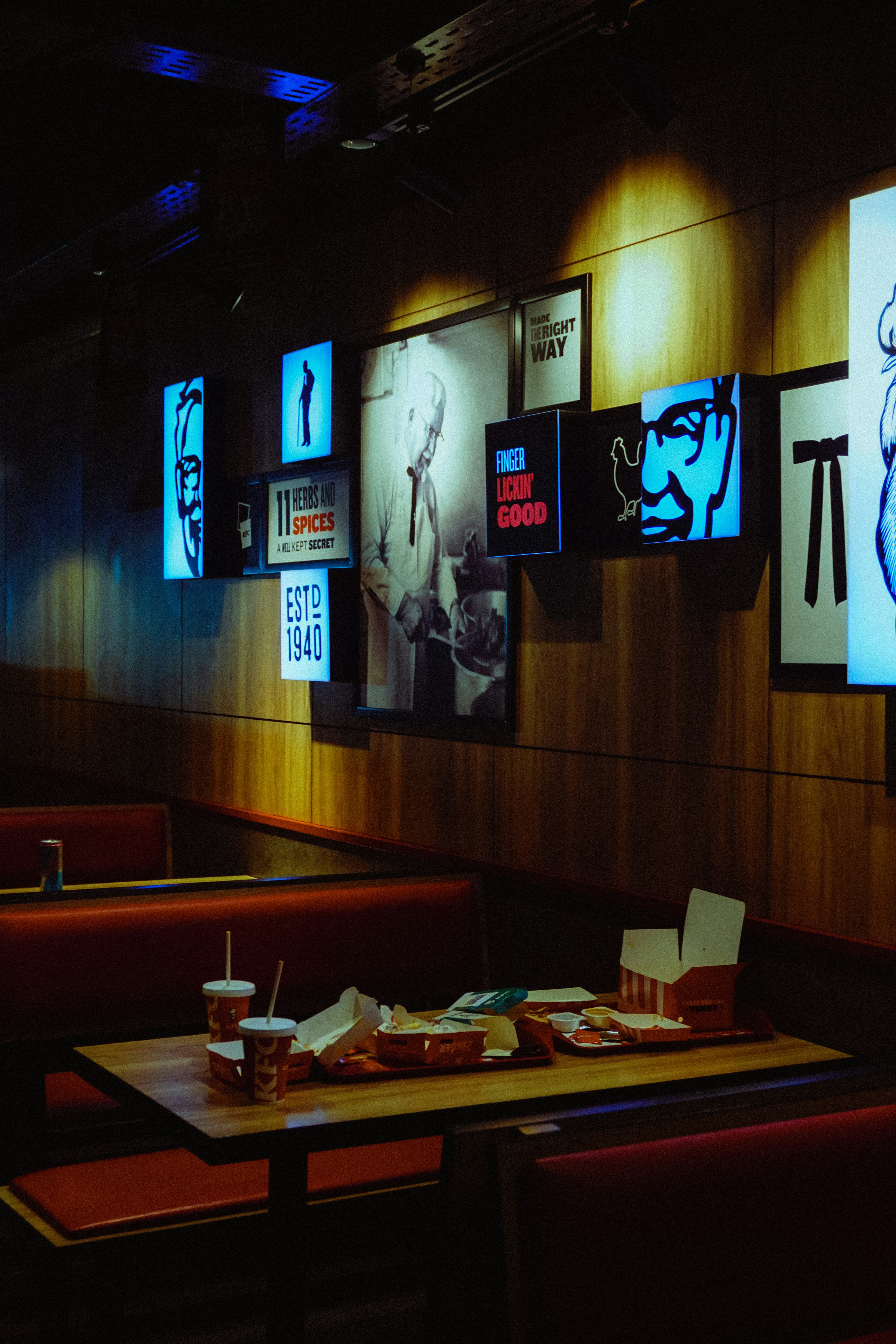 Neon Wall Portraits Over Quiet Booths