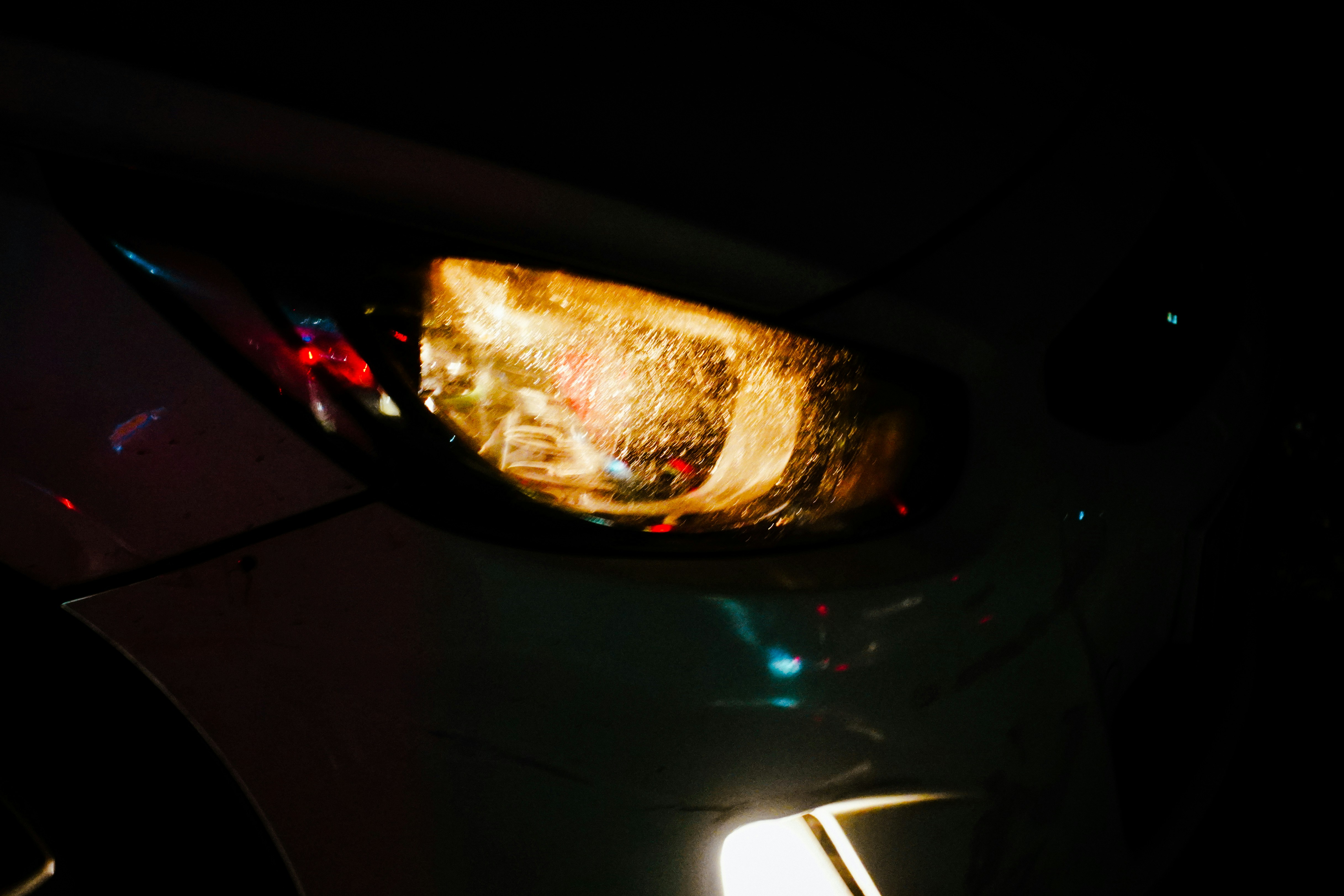 Nightglow in the Car's Gloom: A Close-Up of Headlight and Gloss