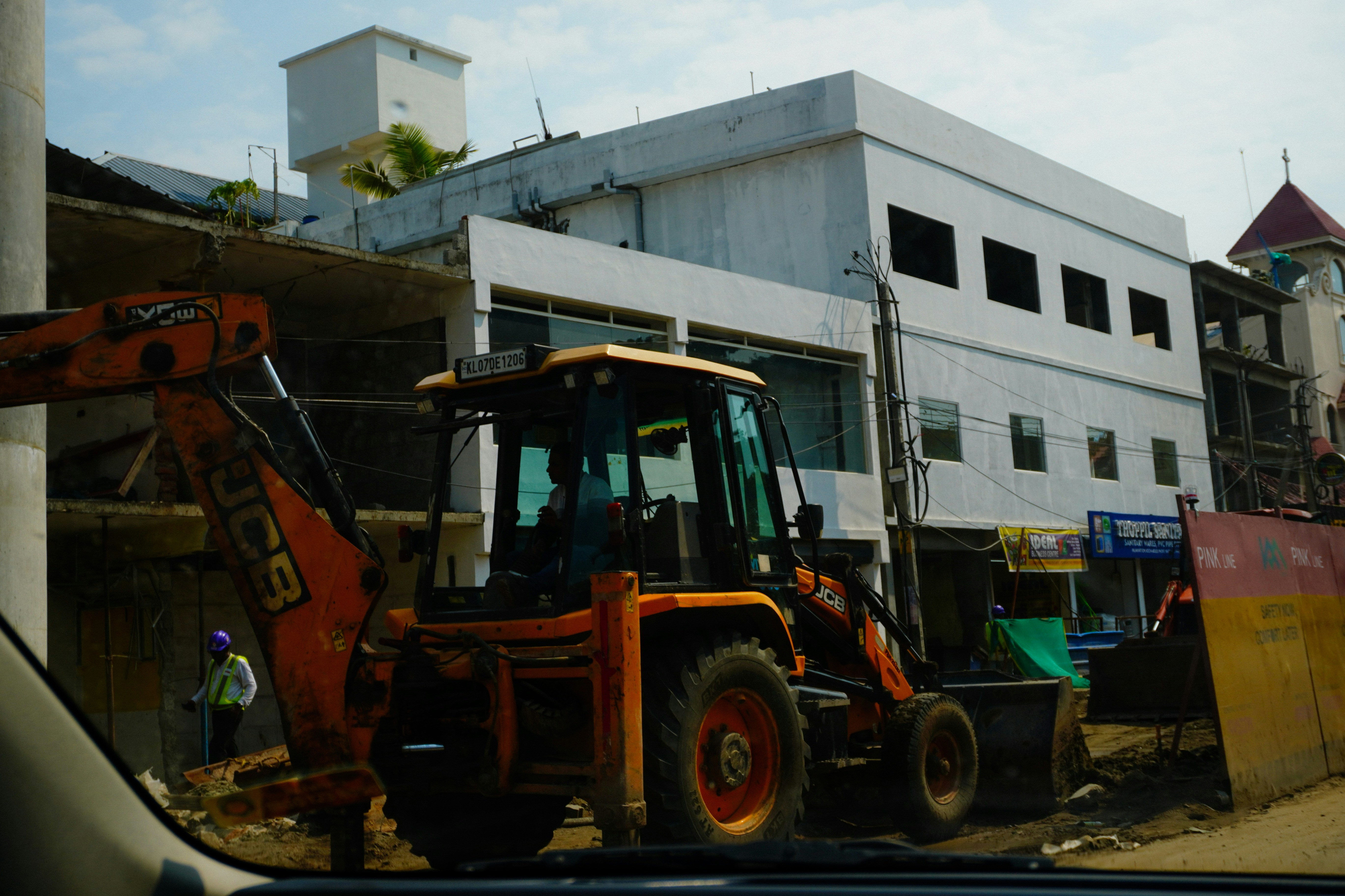 An orange backhoe loader parked at a construction site.