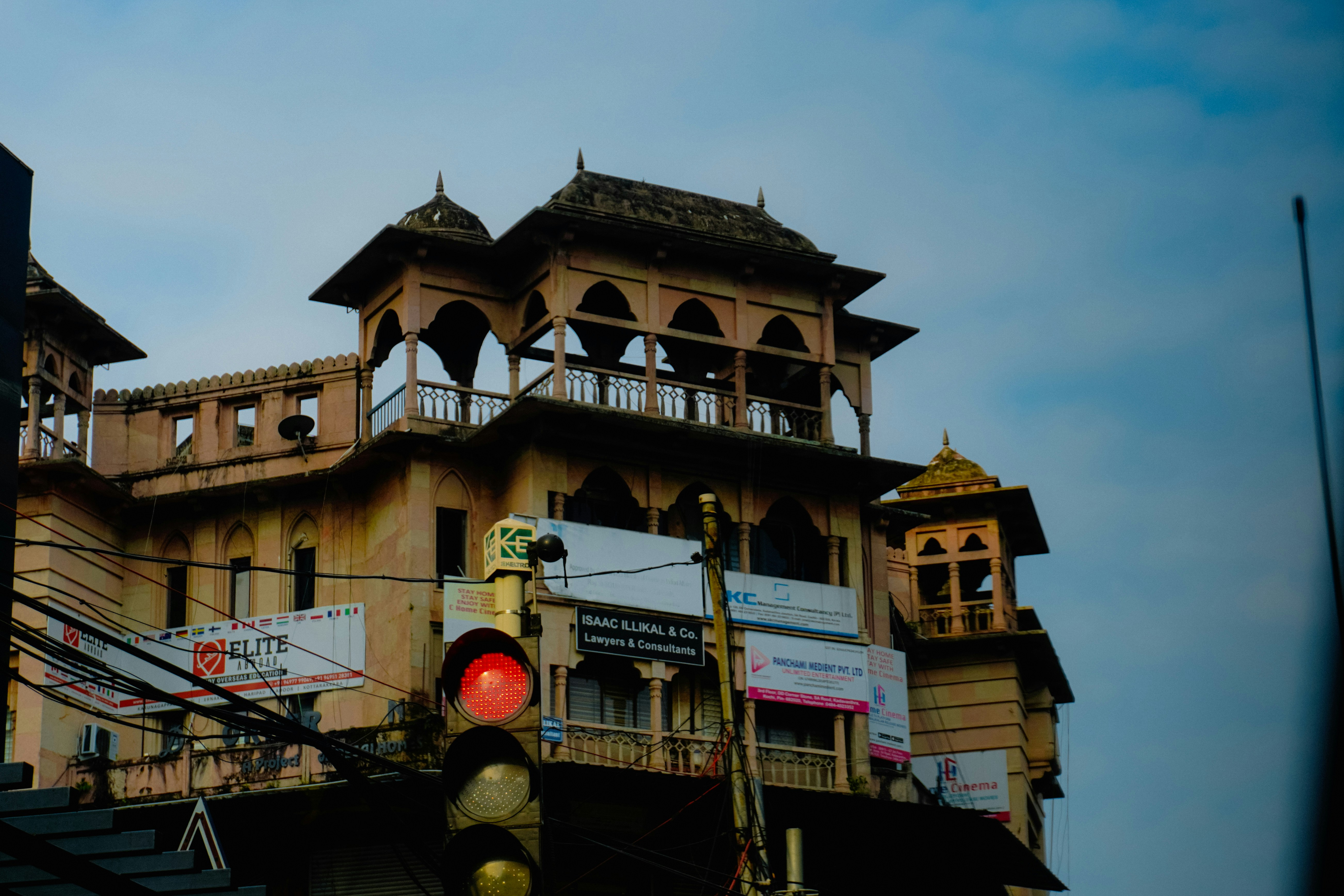 Ornate historic building with balconies and a red traffic light.
