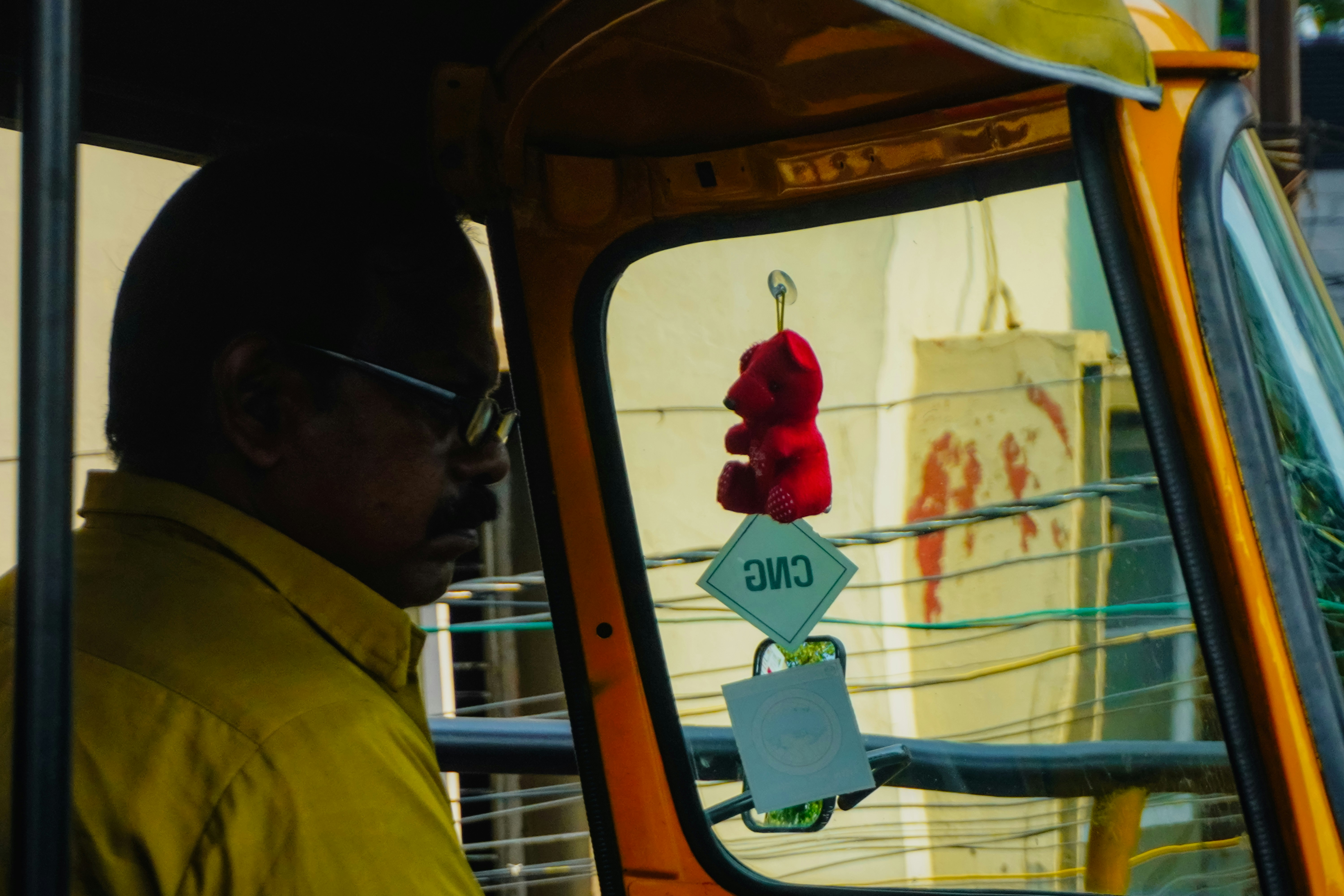 Yellow-Cloaked Driver in an Orange Tracked Vehicle Cab
