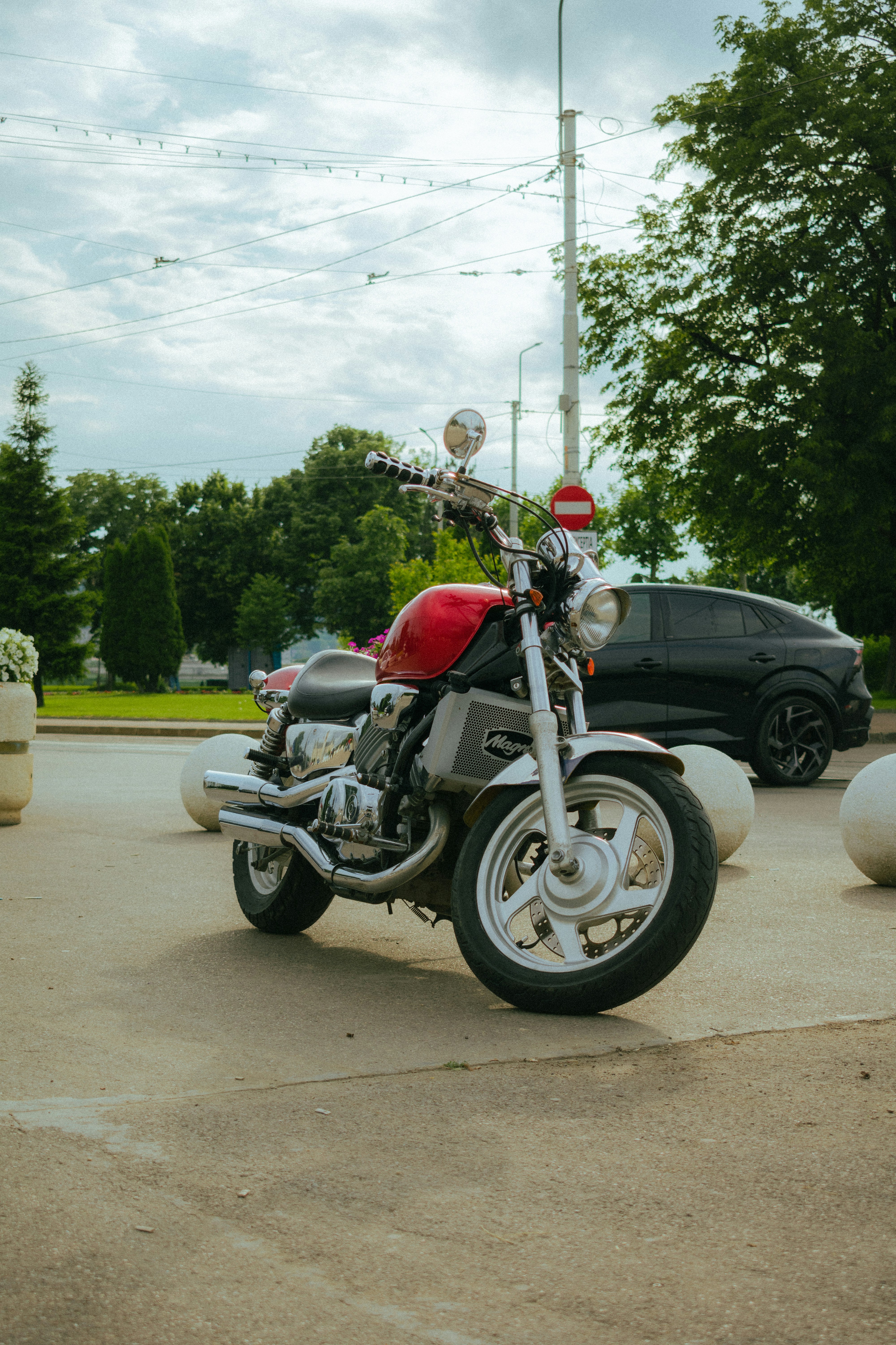 Red Legend on Wheels: A Classic Motorcycle Stands Proud in a Quiet Plaza