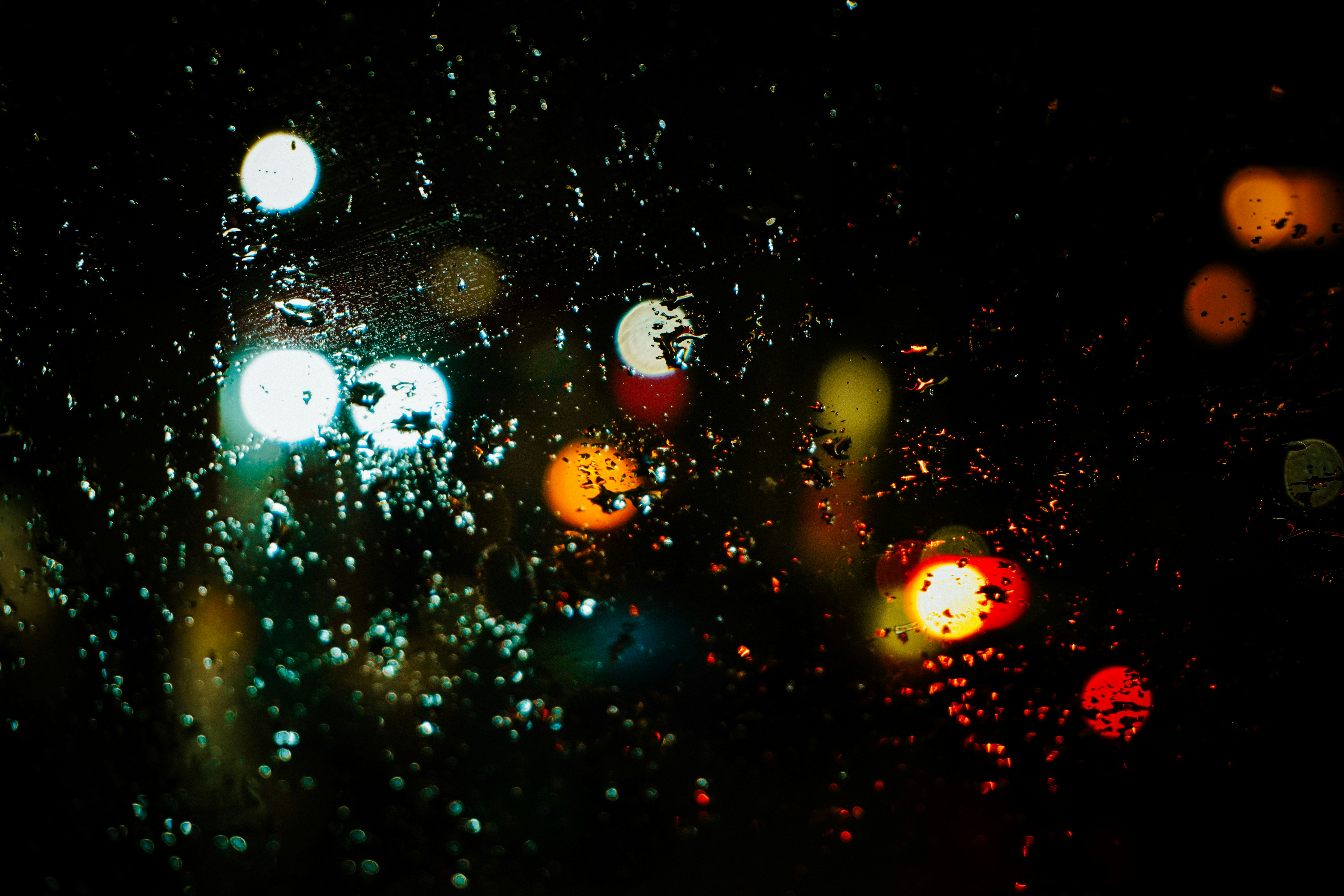 Abstract bokeh lights with water droplets on a dark background.