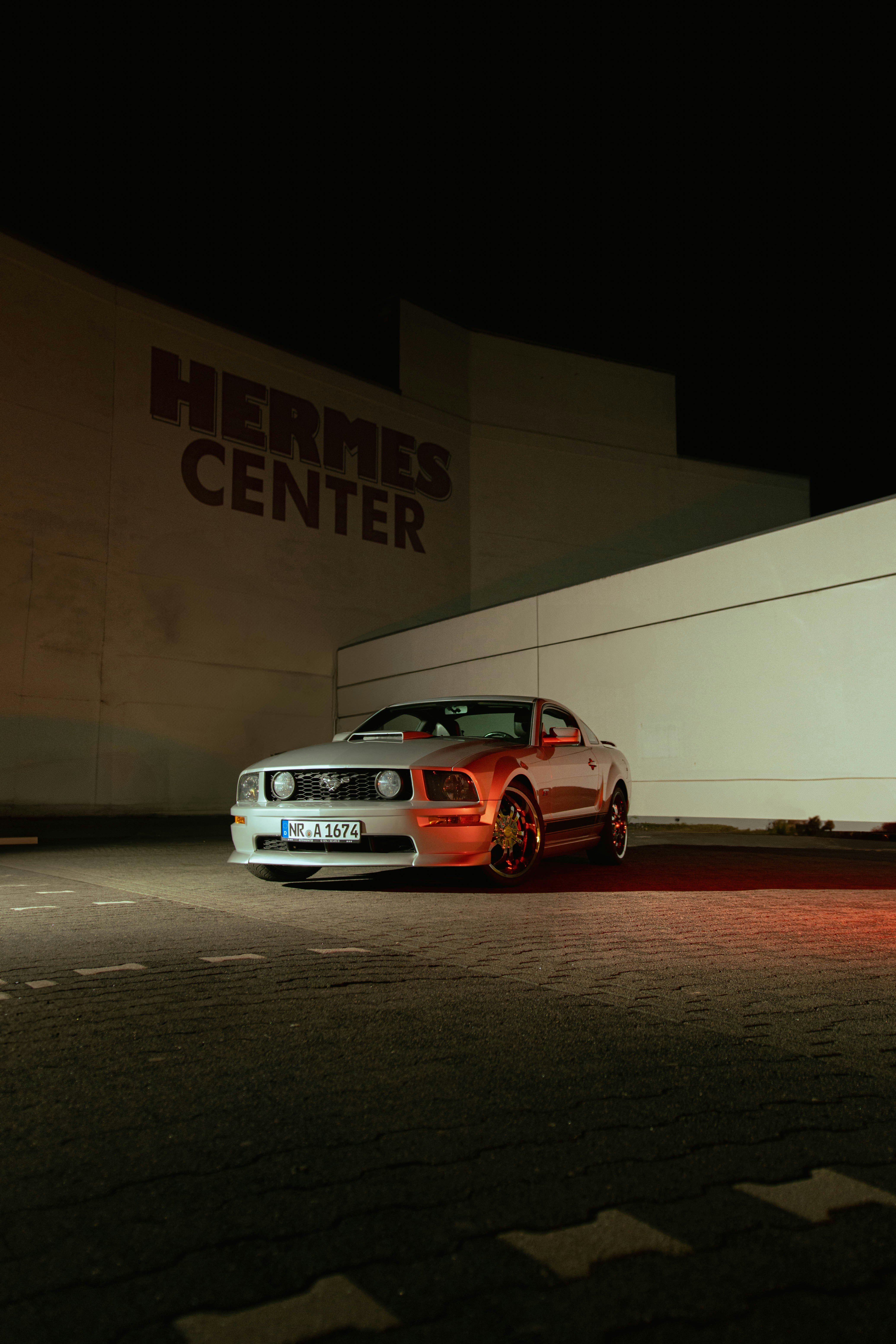 Night Stance at Hermes Center: A Silver Mustang Under Neon Accent