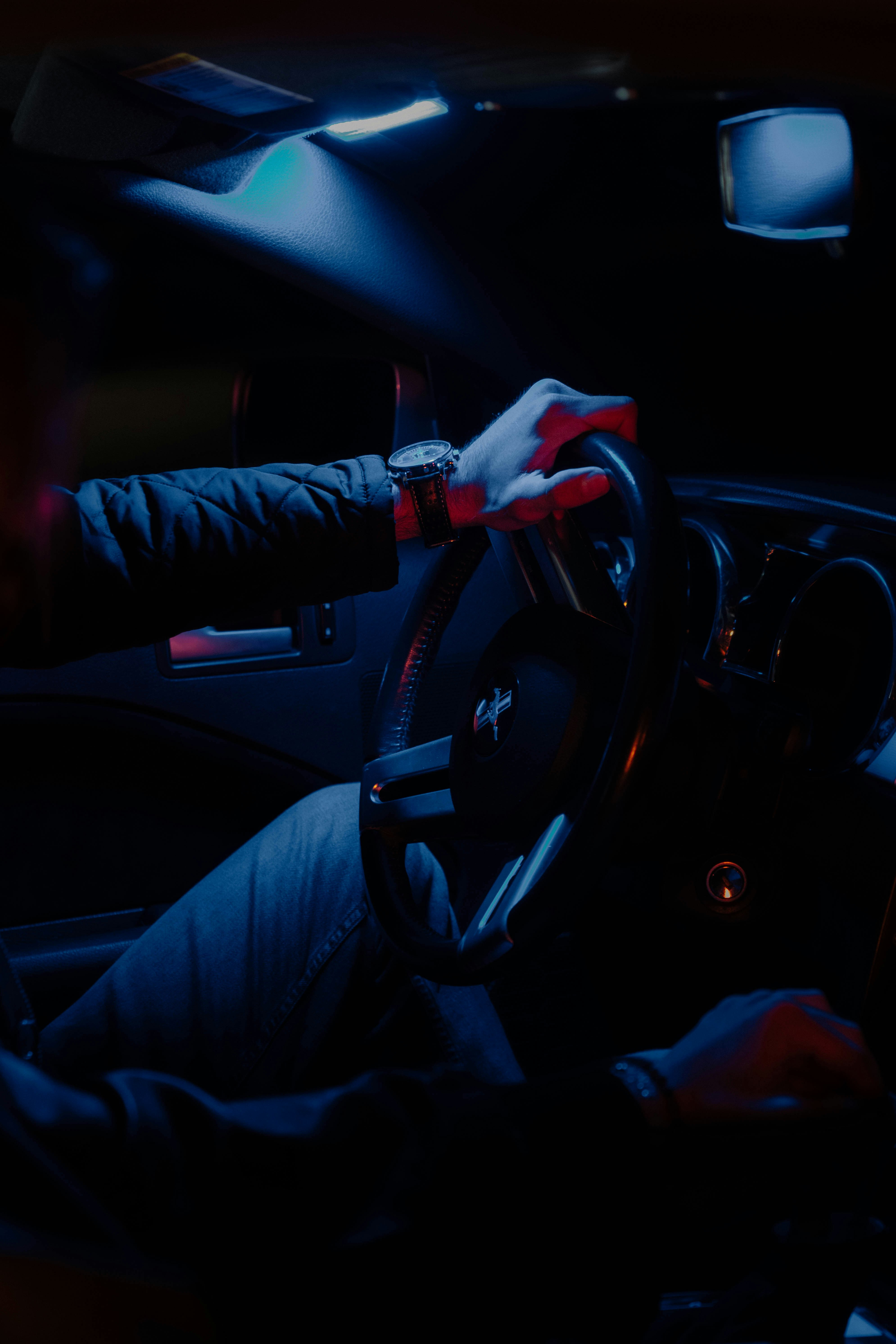 Midnight Drive: A Hand on the Wheel under Neon Blue