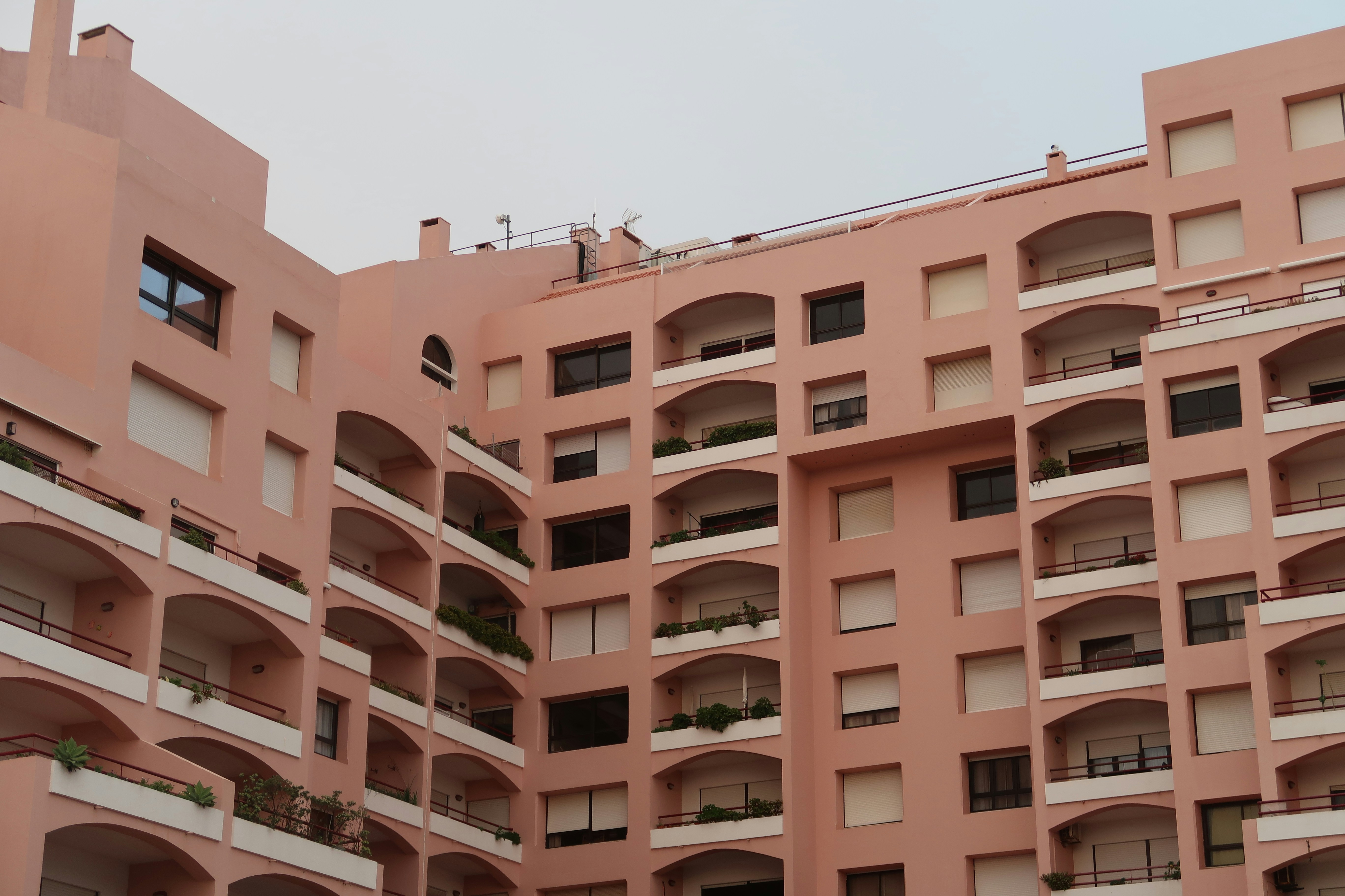 Large pink building with many arched windows and balconies.
