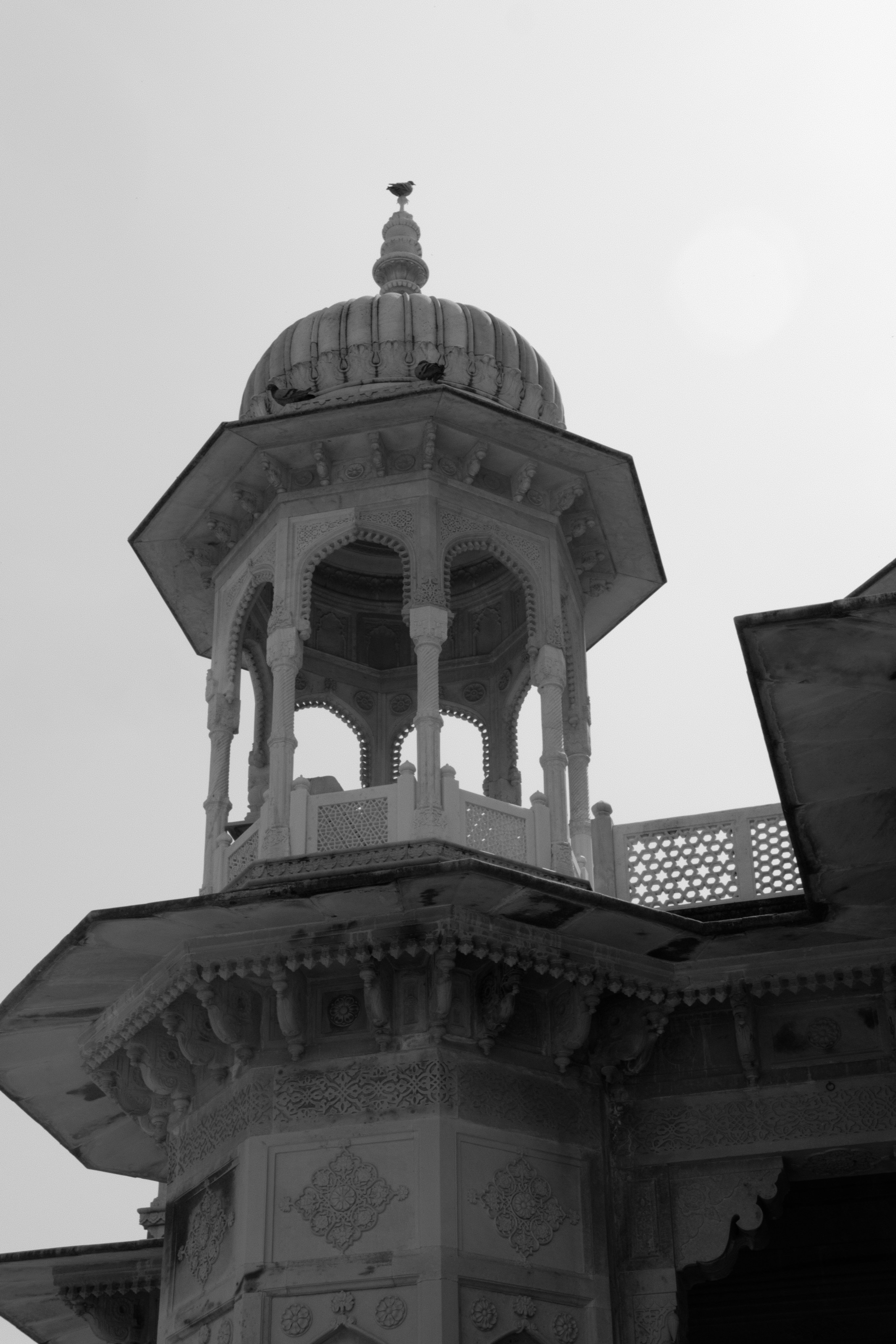 A Dusk-Quiet Cenotaph: The Carved Dome Overlooking a Lattice Balcony