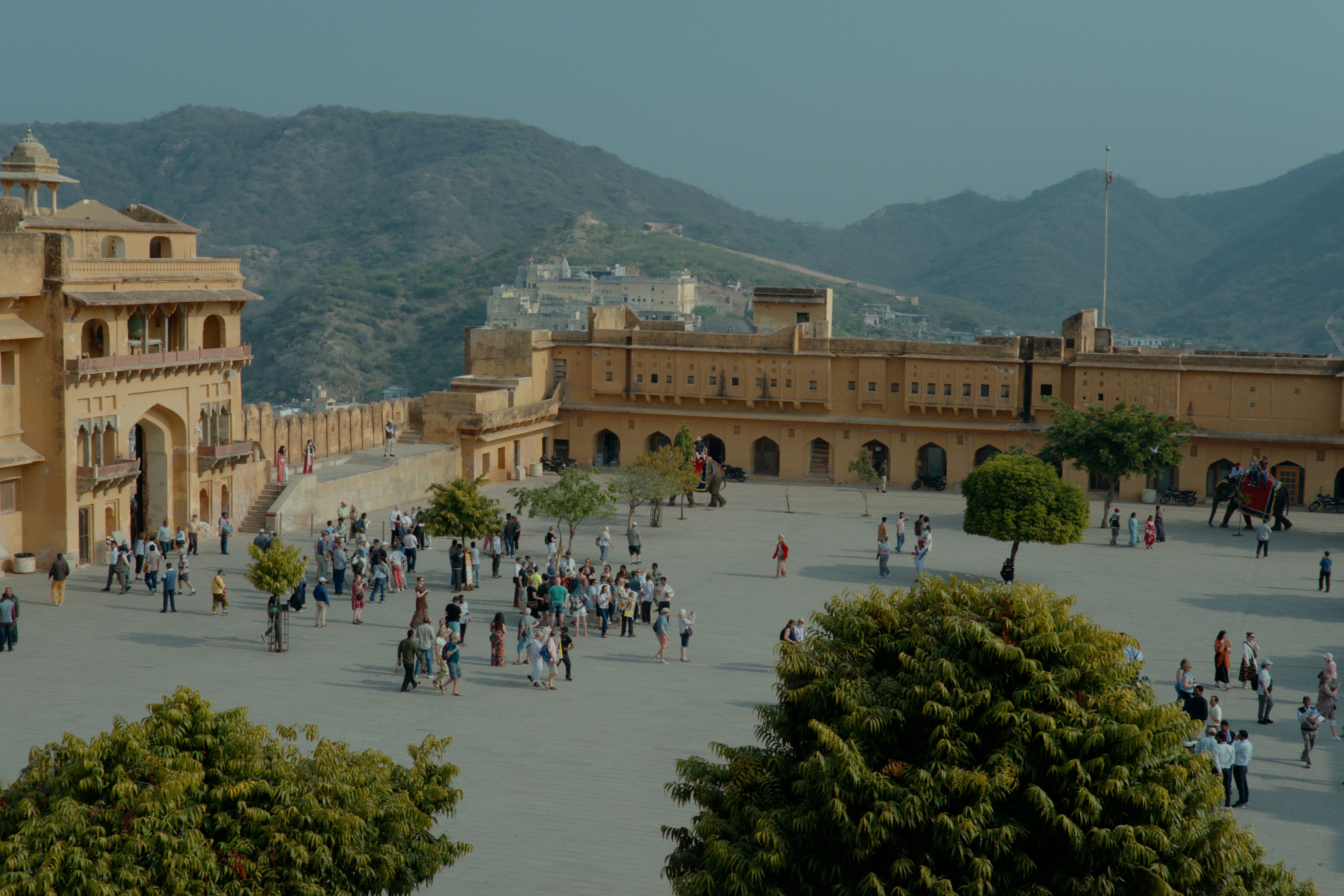 Timeless Courtyard: People and Monolithic Forts under a Mountain Range