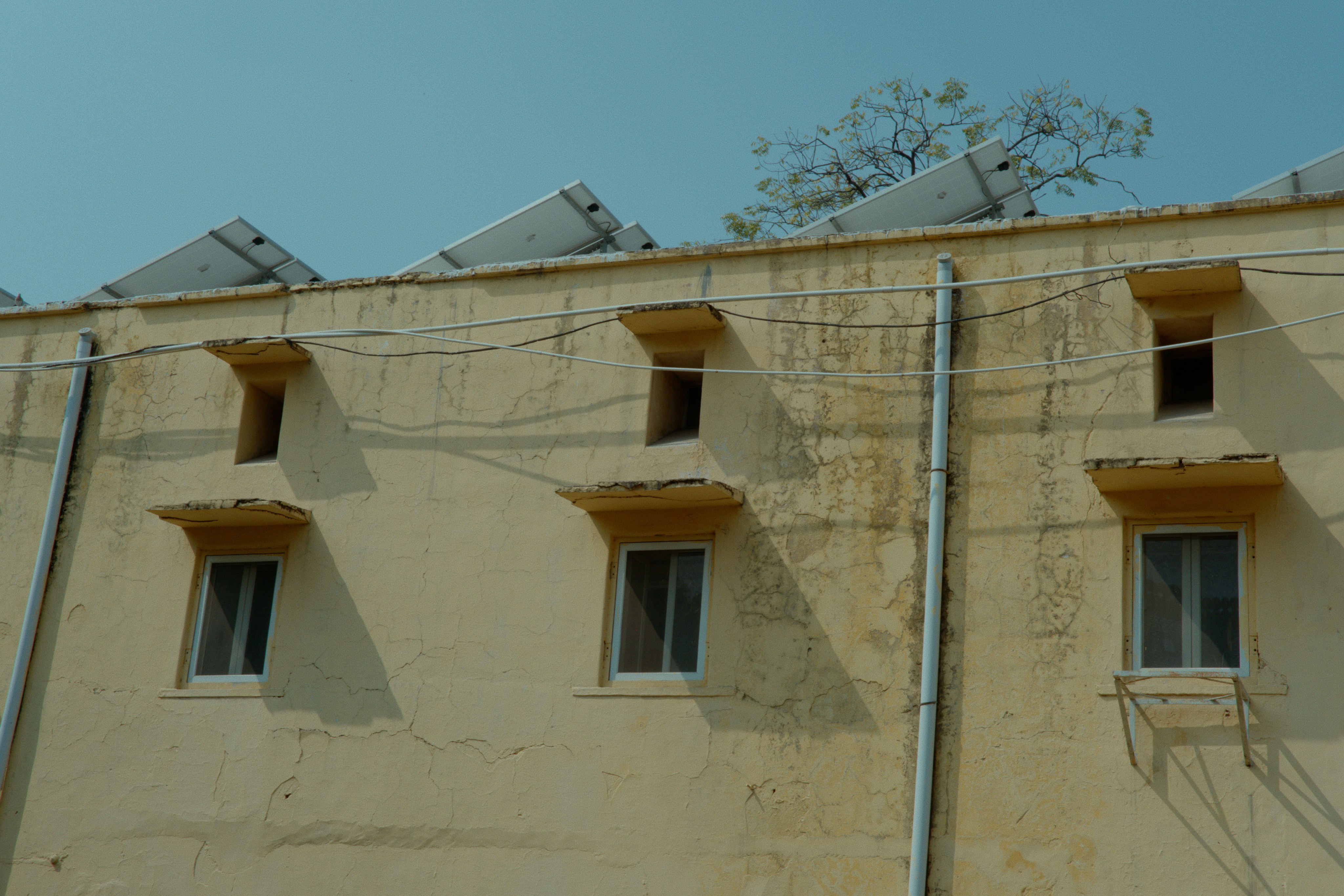 Beige building with windows and solar panels on roof.