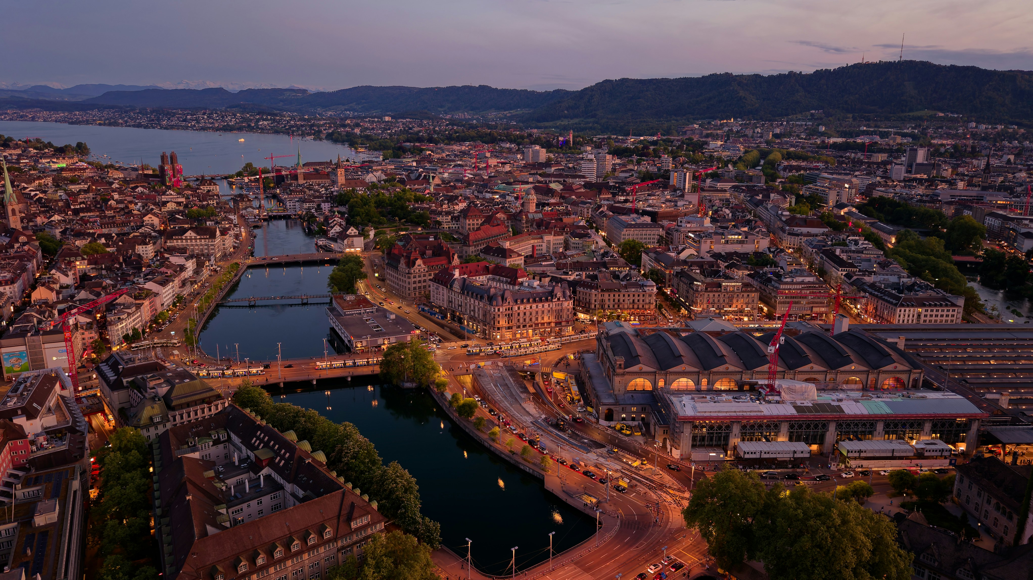 Dusk over a bustling city with river and lake.