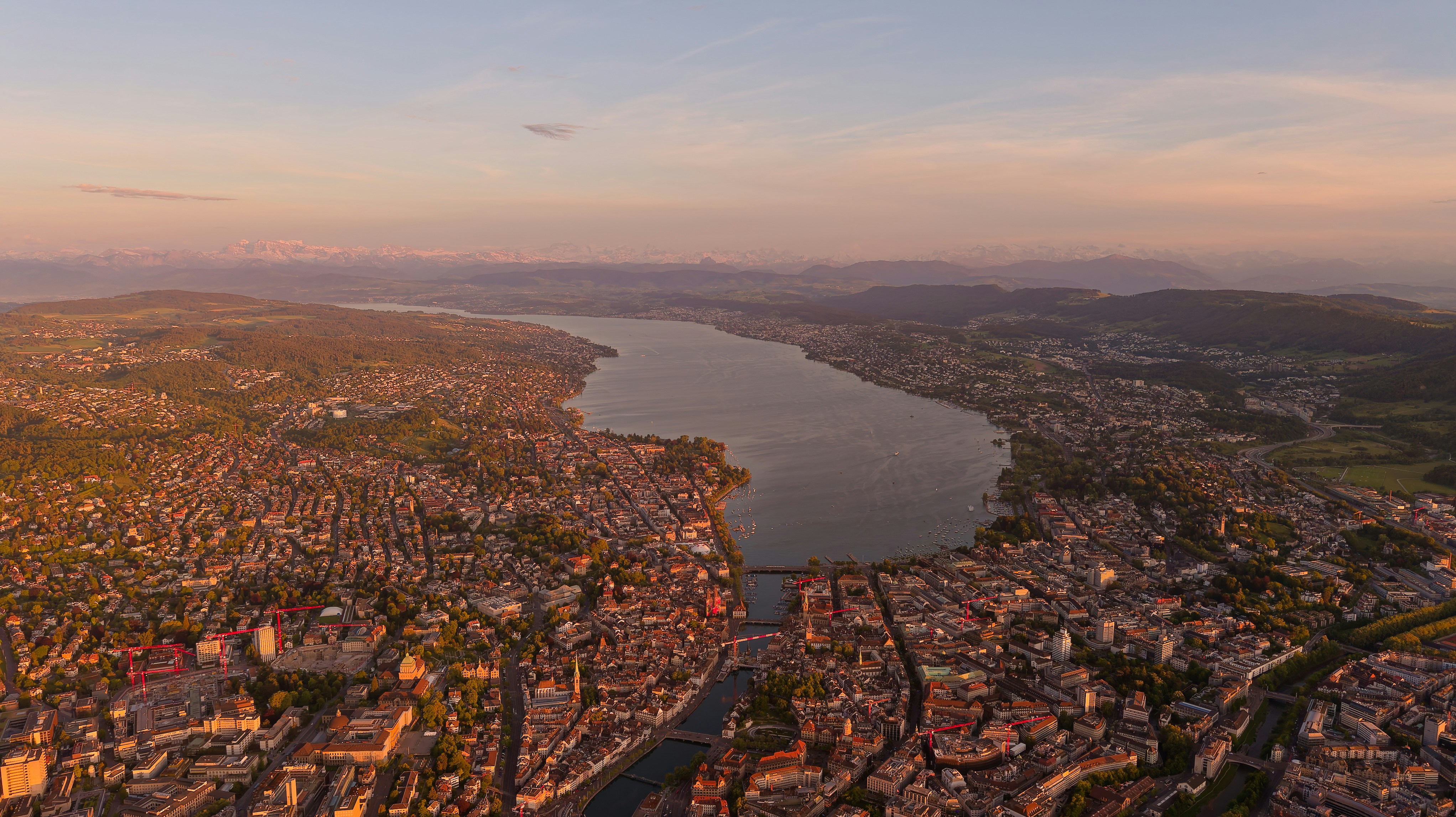 Aerial view of a city and lake at sunset.
