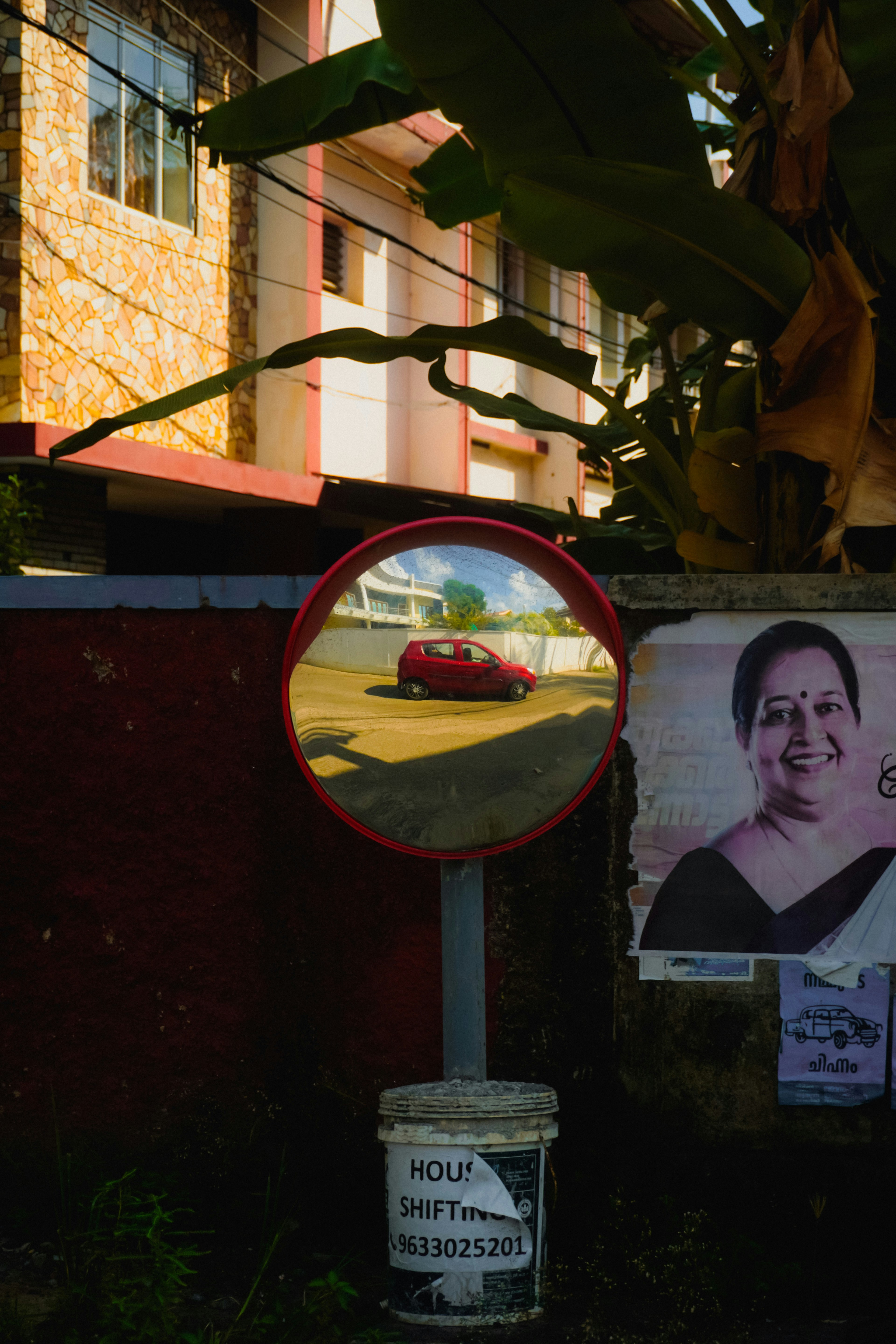 Red Car in Circular Mirror: Urban Echoes