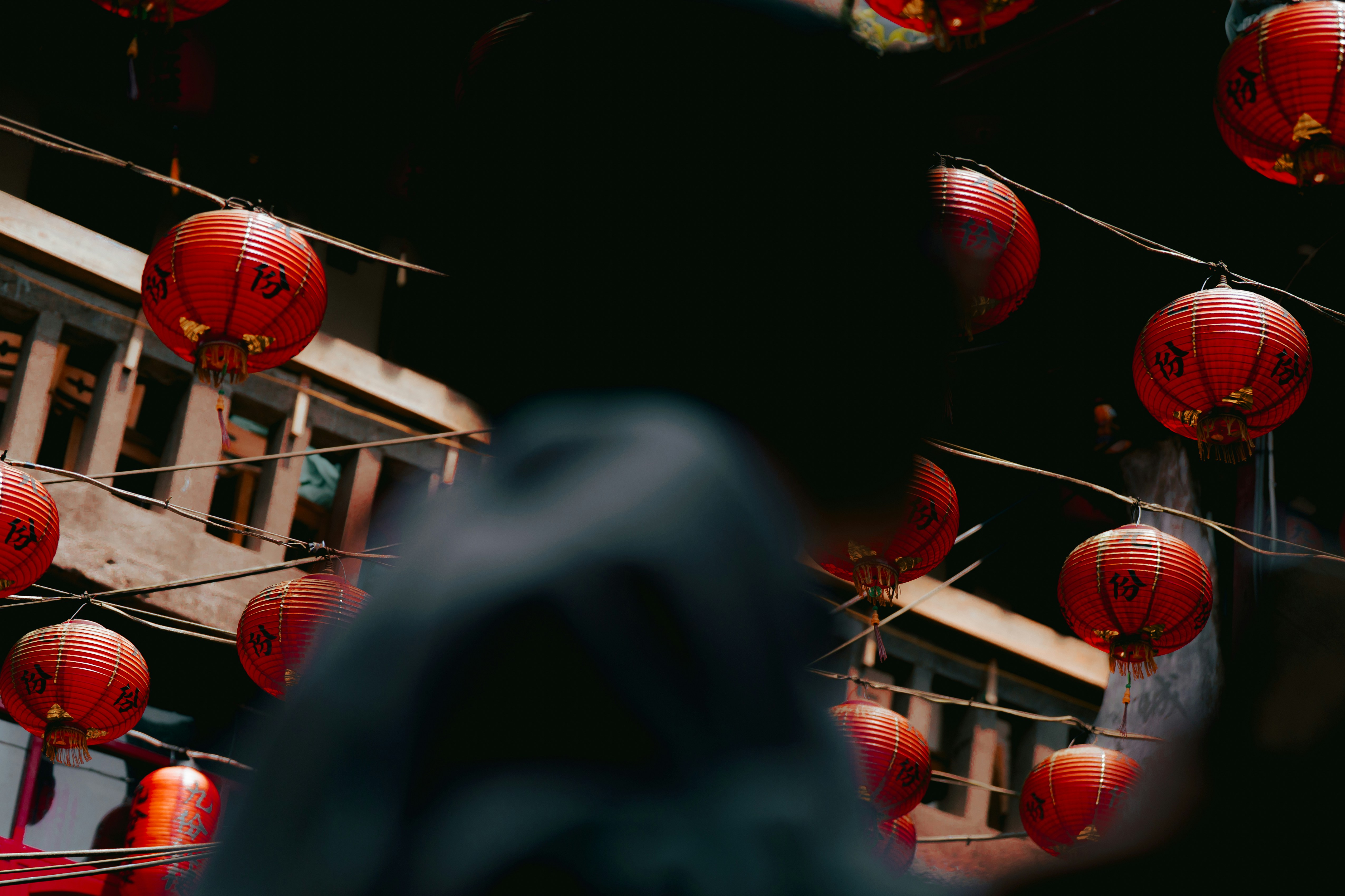 Lanterns in Motion: A Blurred Portrait Beneath Red Orbs