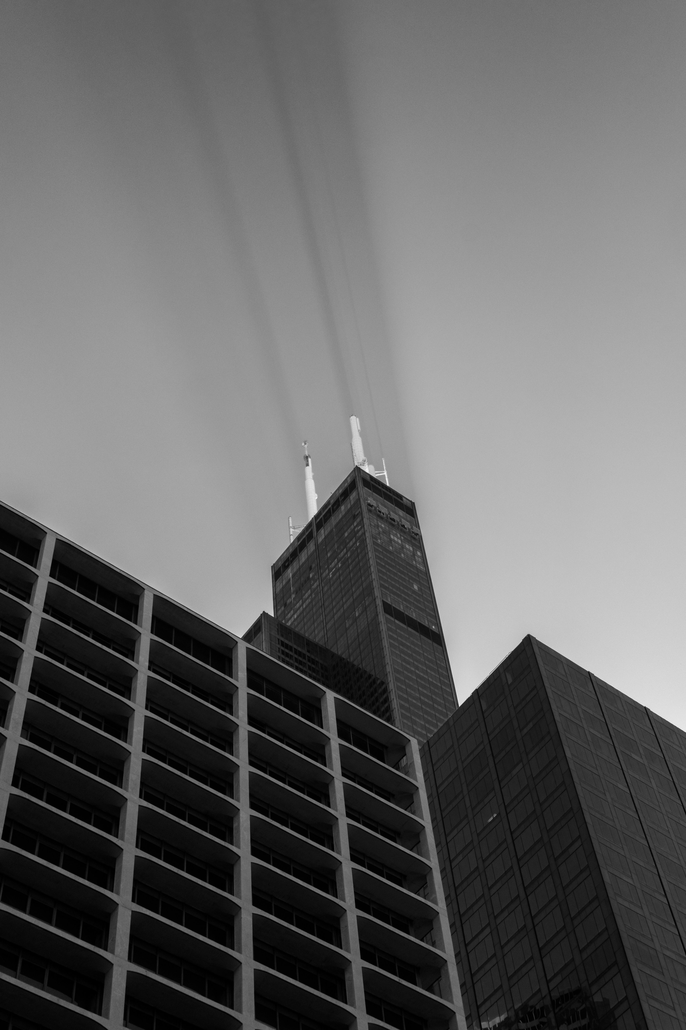 Tilted Skyward: Skyscraper Antenna Trails over Geometric City Facades