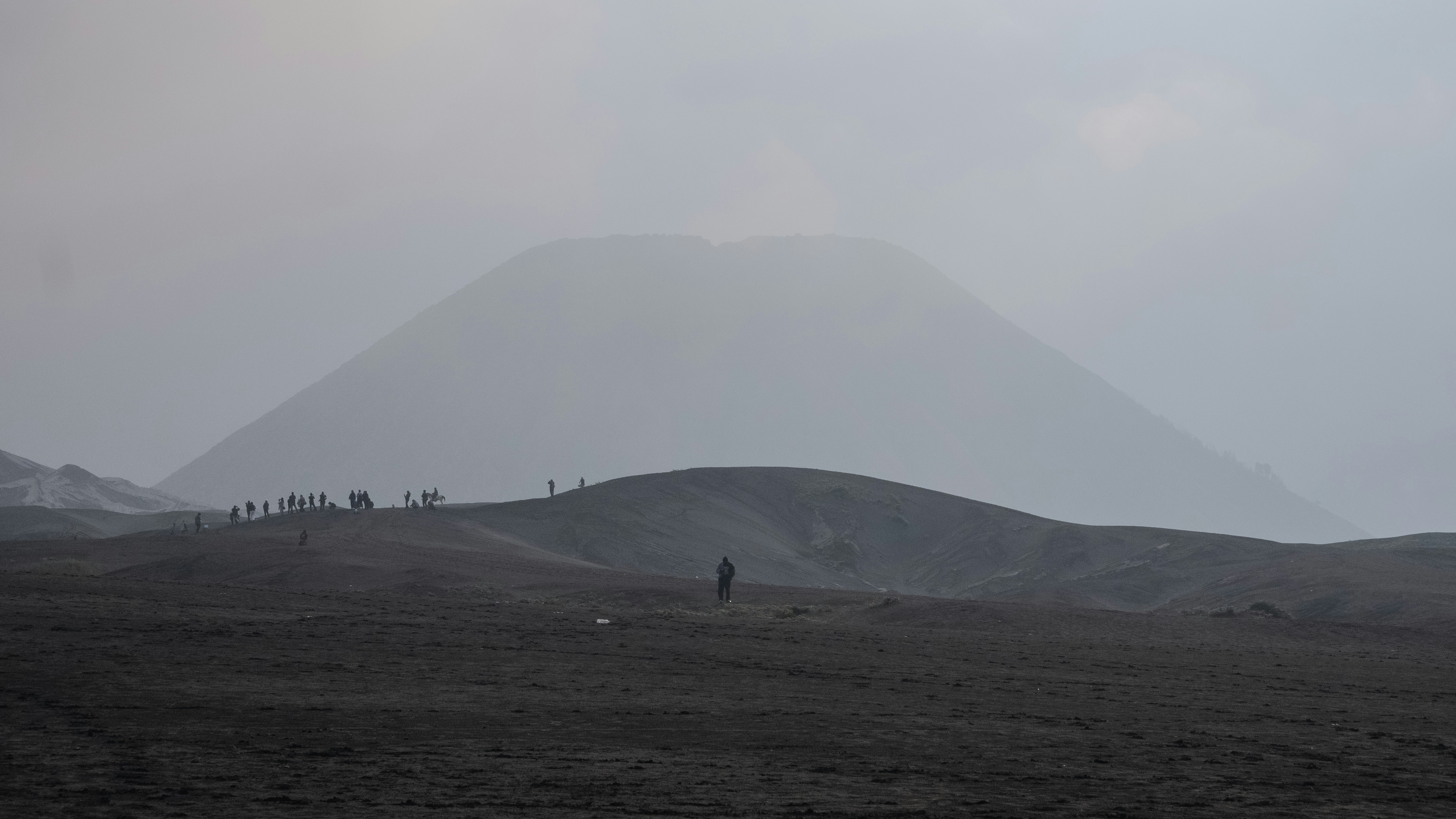 Silhouetted Summit: A Quiet Trek Toward a Misty Volcano