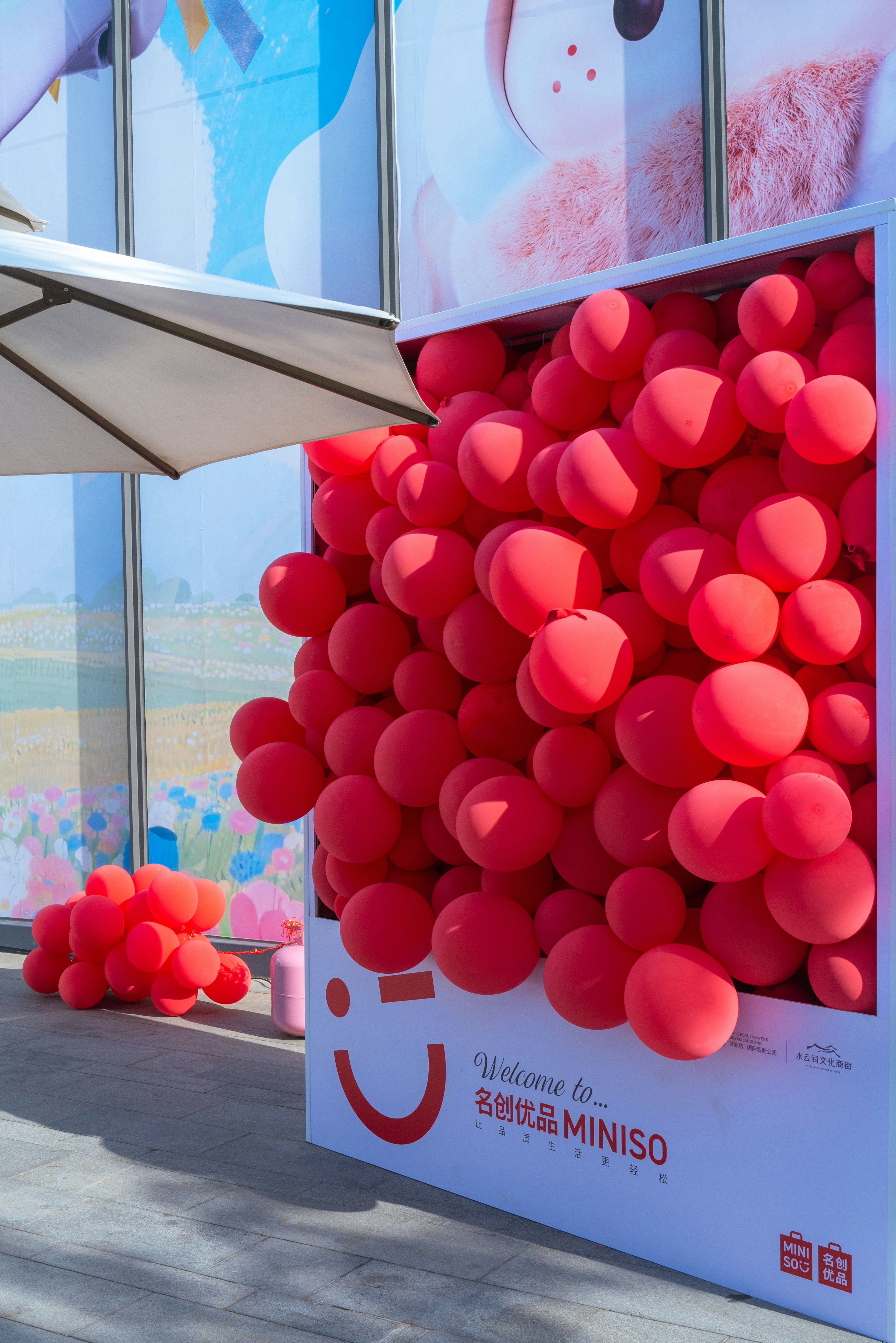 Vibrant red balloons overflowing from a white display frame.
