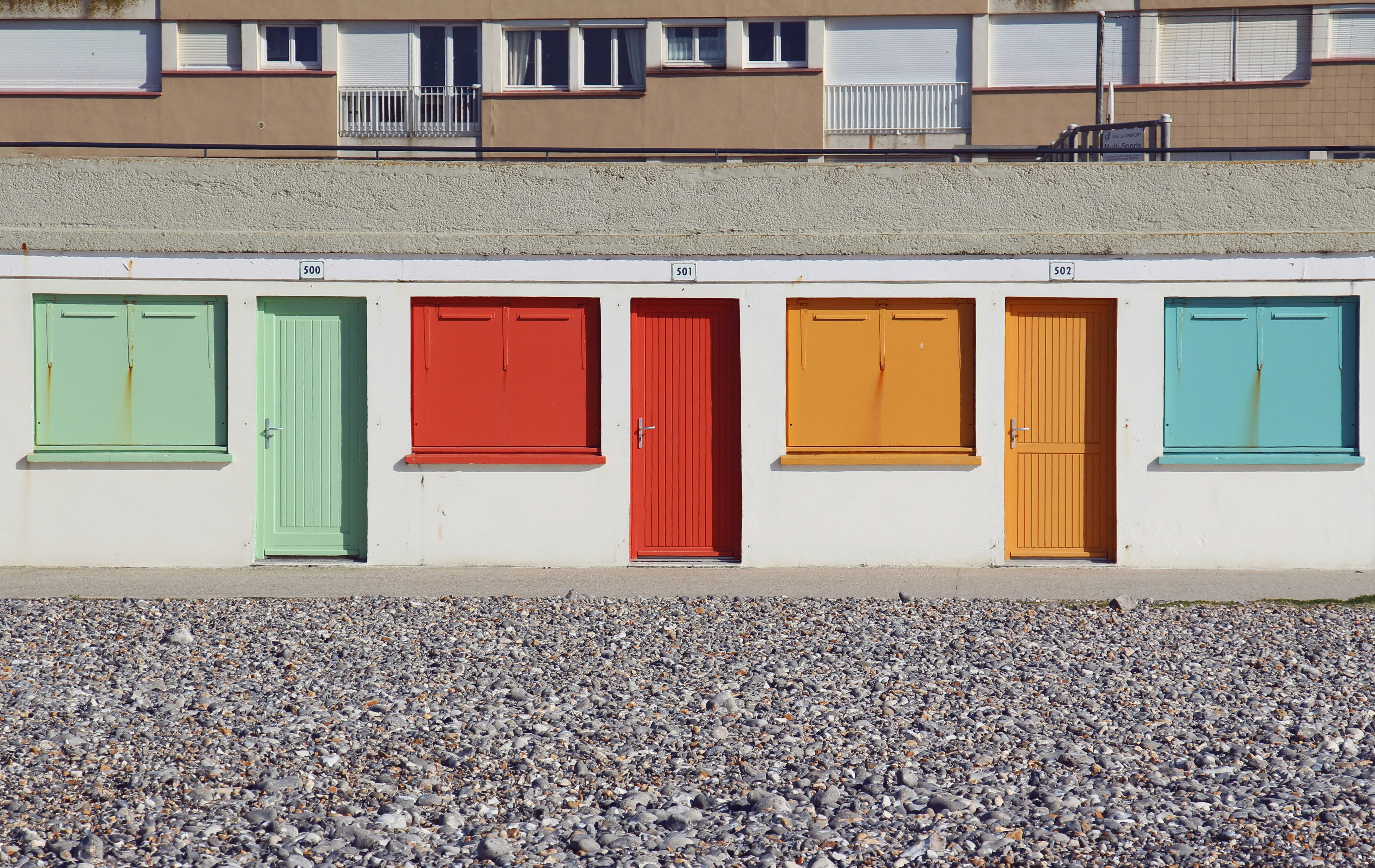 Row of Painted Beach Cabins Beneath a Quiet Seaside Sky
