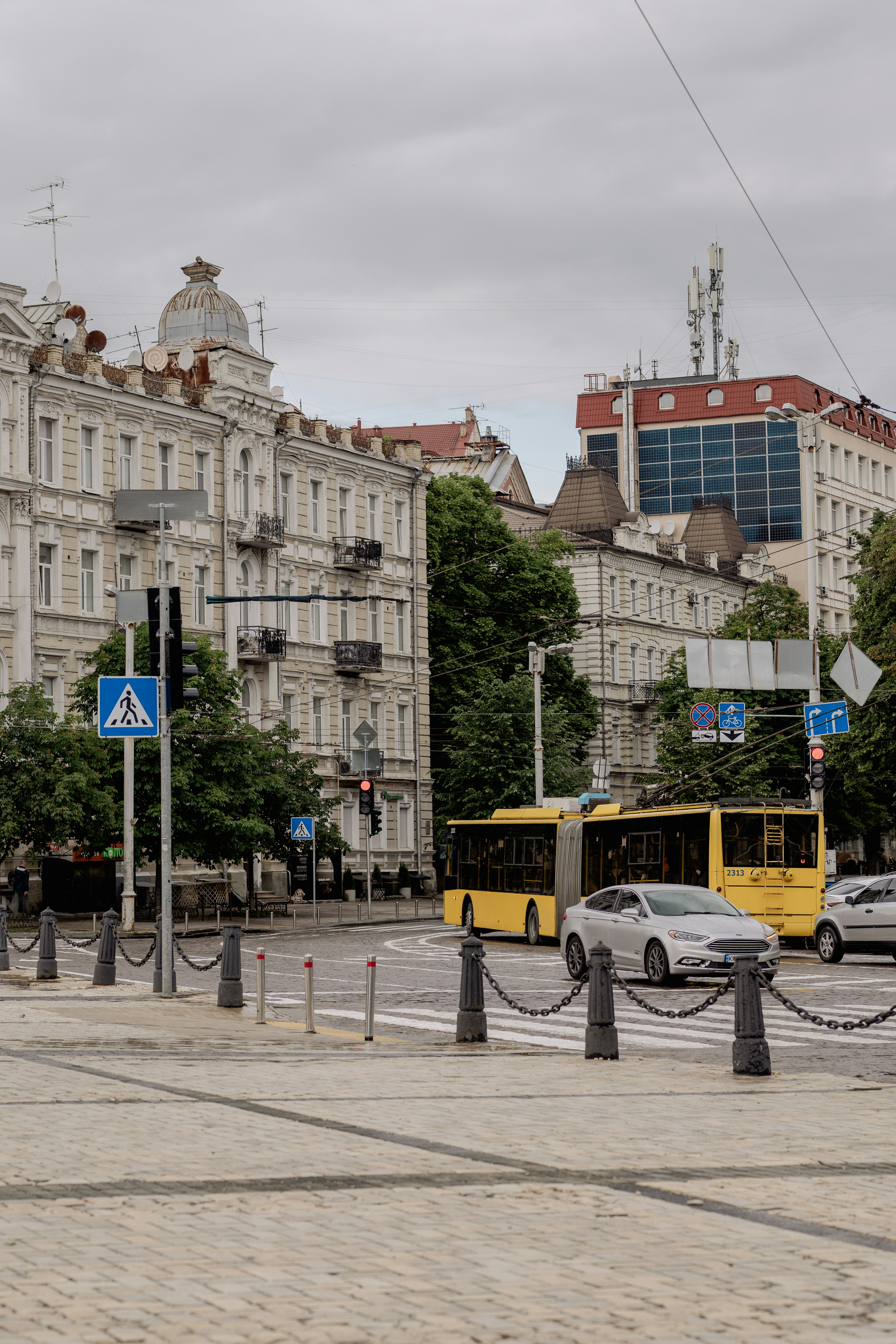 Urban Crossroads: Yellow Bus, Pedestrians, and Historic Facades