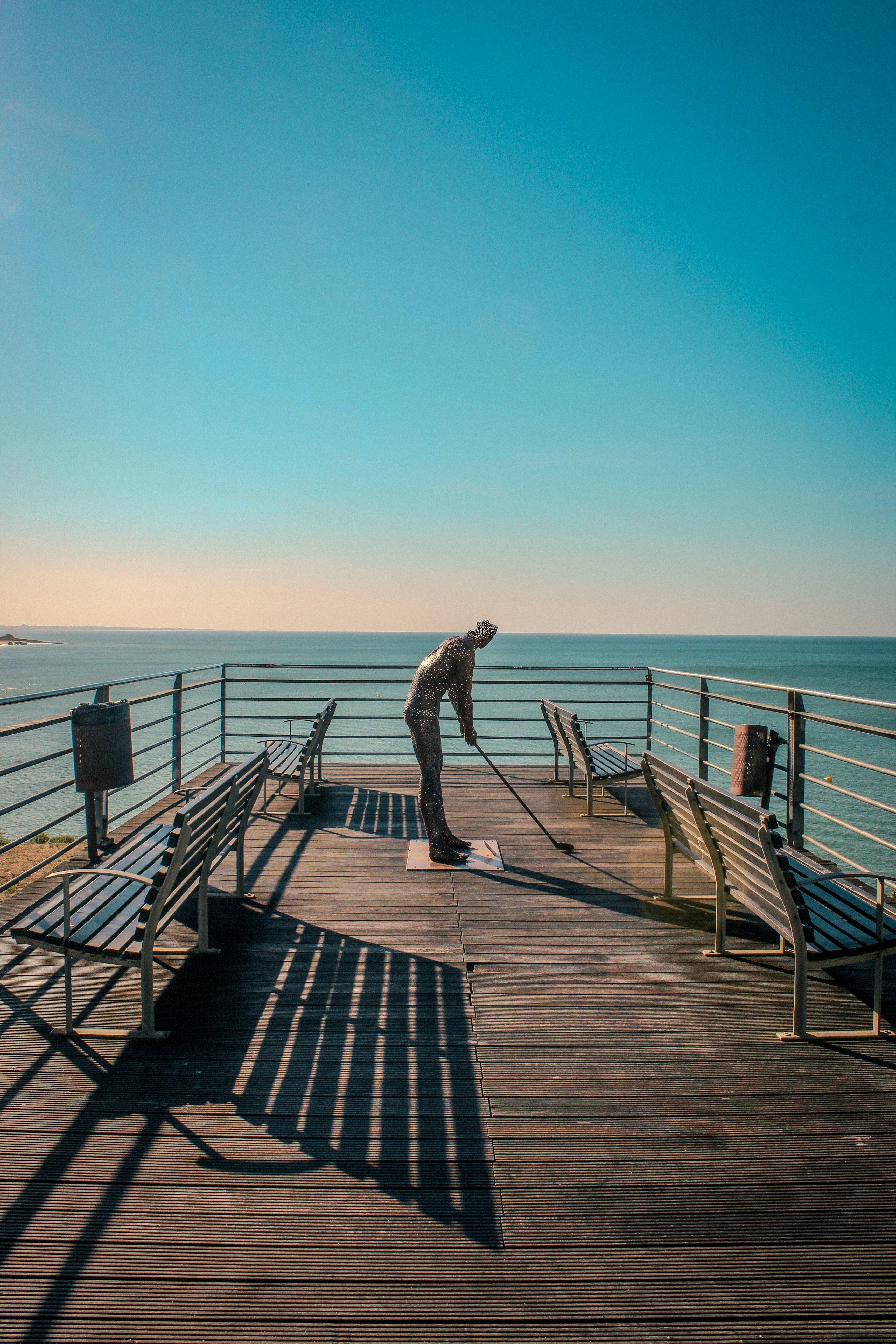 Pier Top Gambit: A solitary figure bends at the end of the deck