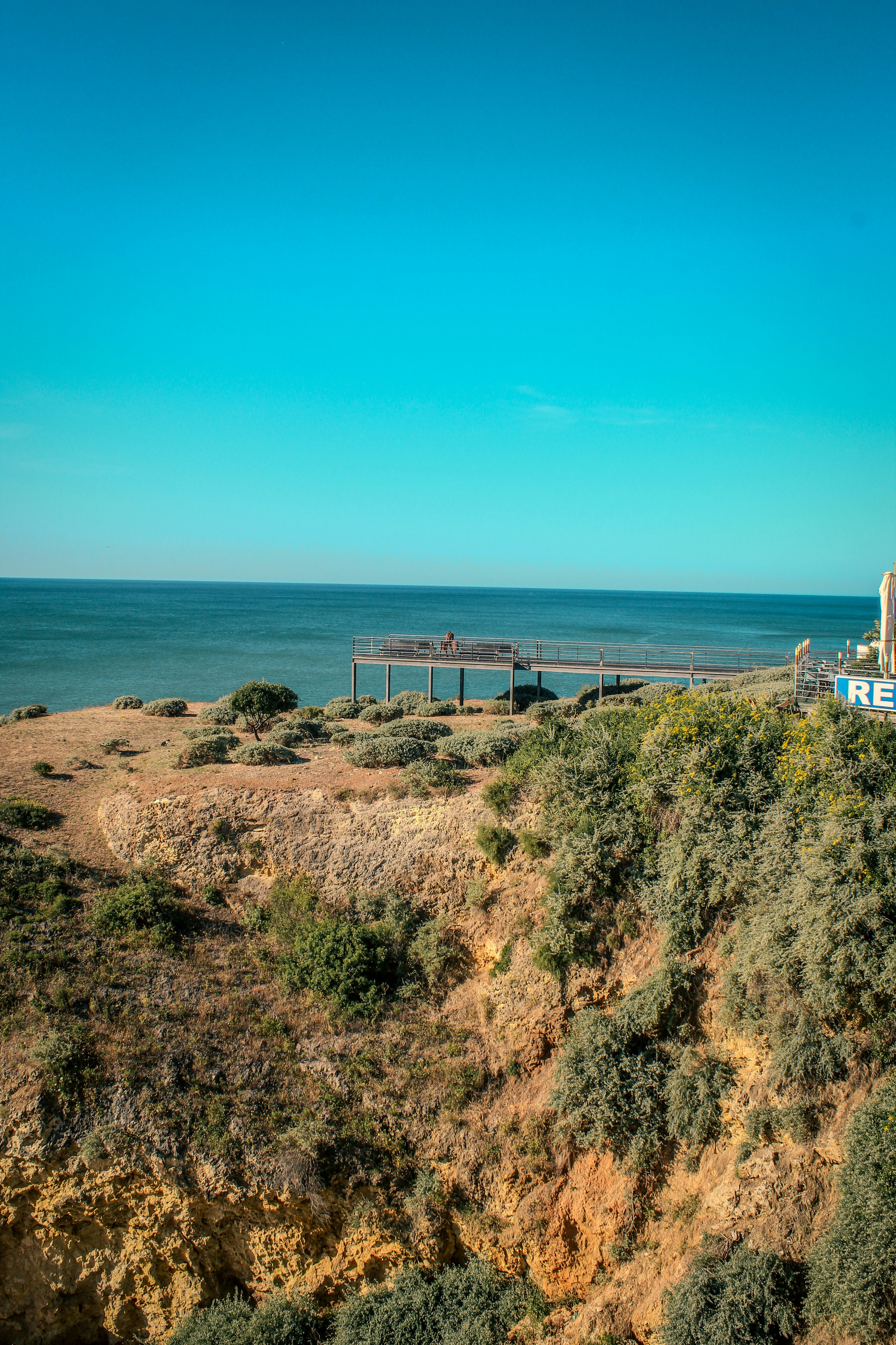 Coastal Cliffside Overlook with Pier Reaching the Calm Atlantic