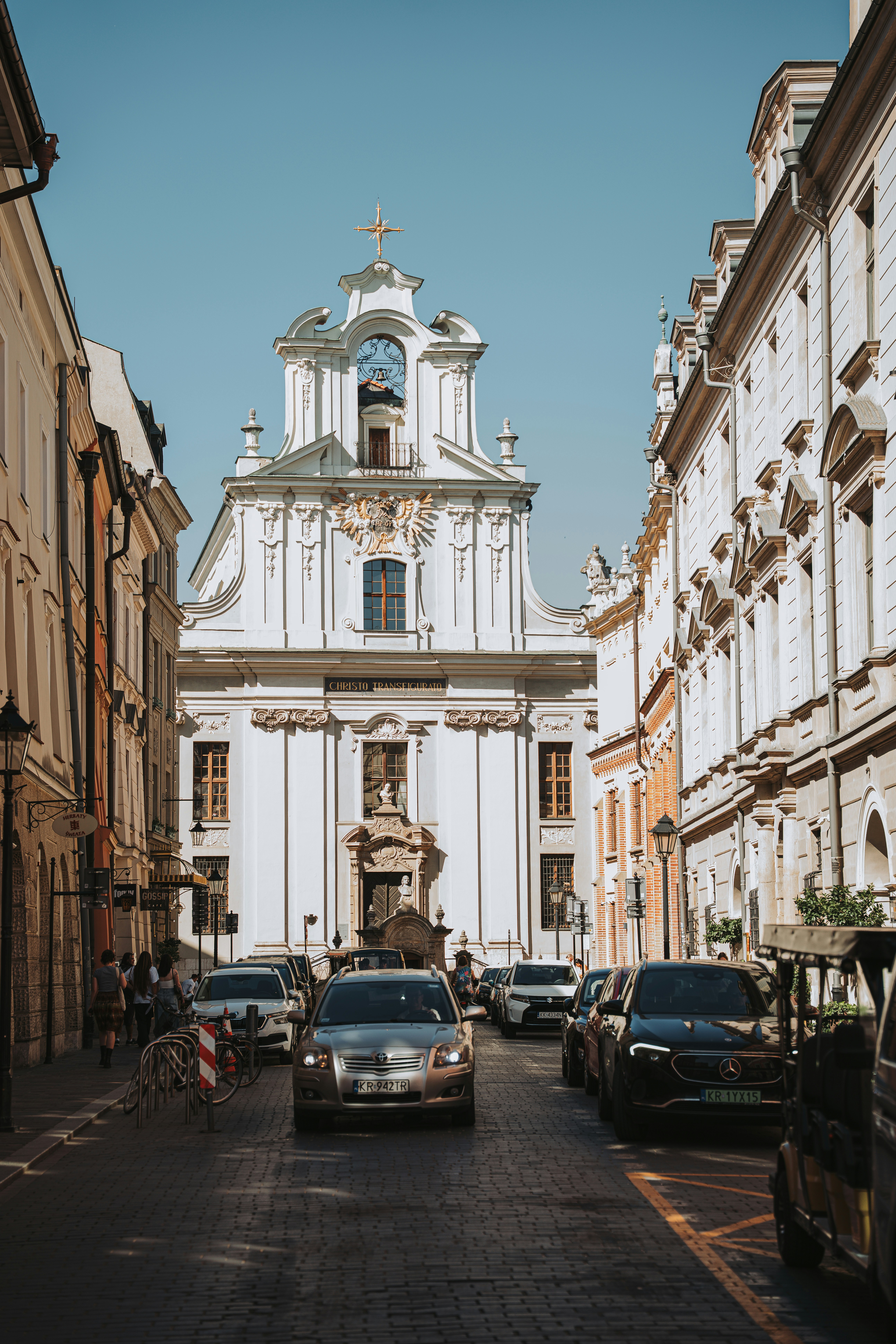 White church at the end of a street with cars.