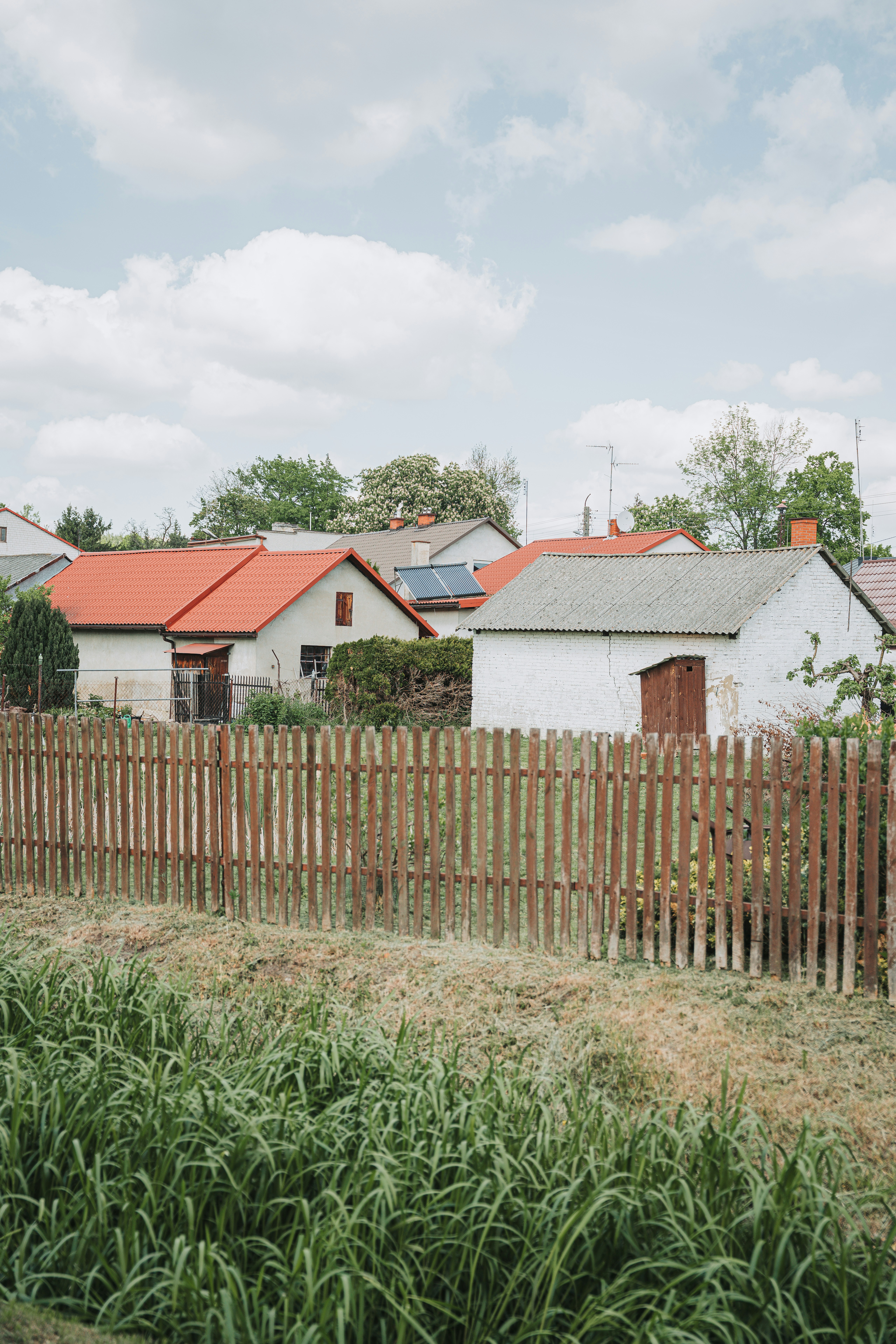 Red-roofed cottages behind a weathered wooden fence