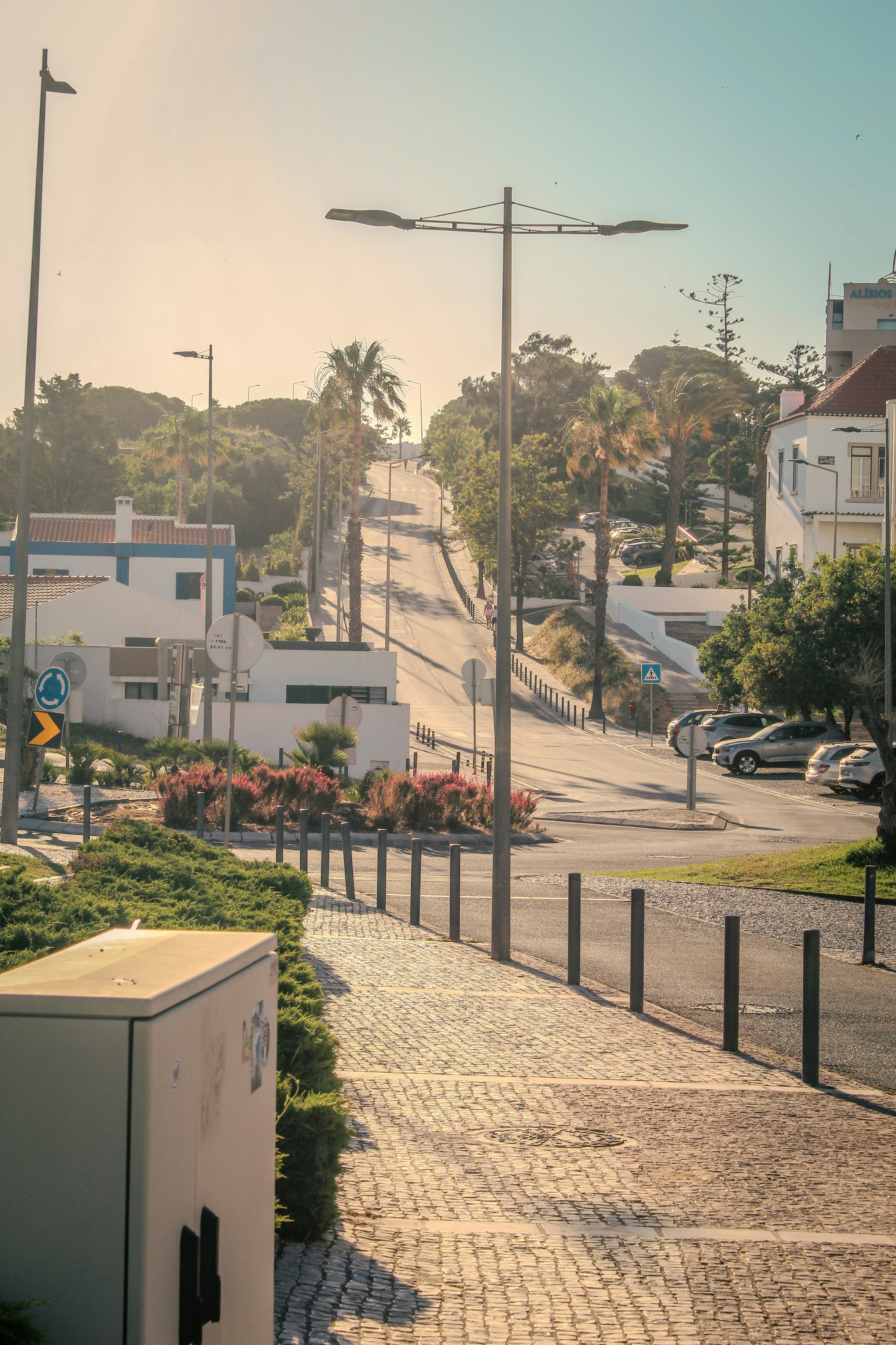Sunlit Coastal Street: A Quiet Slope Between Whitewashed Homes