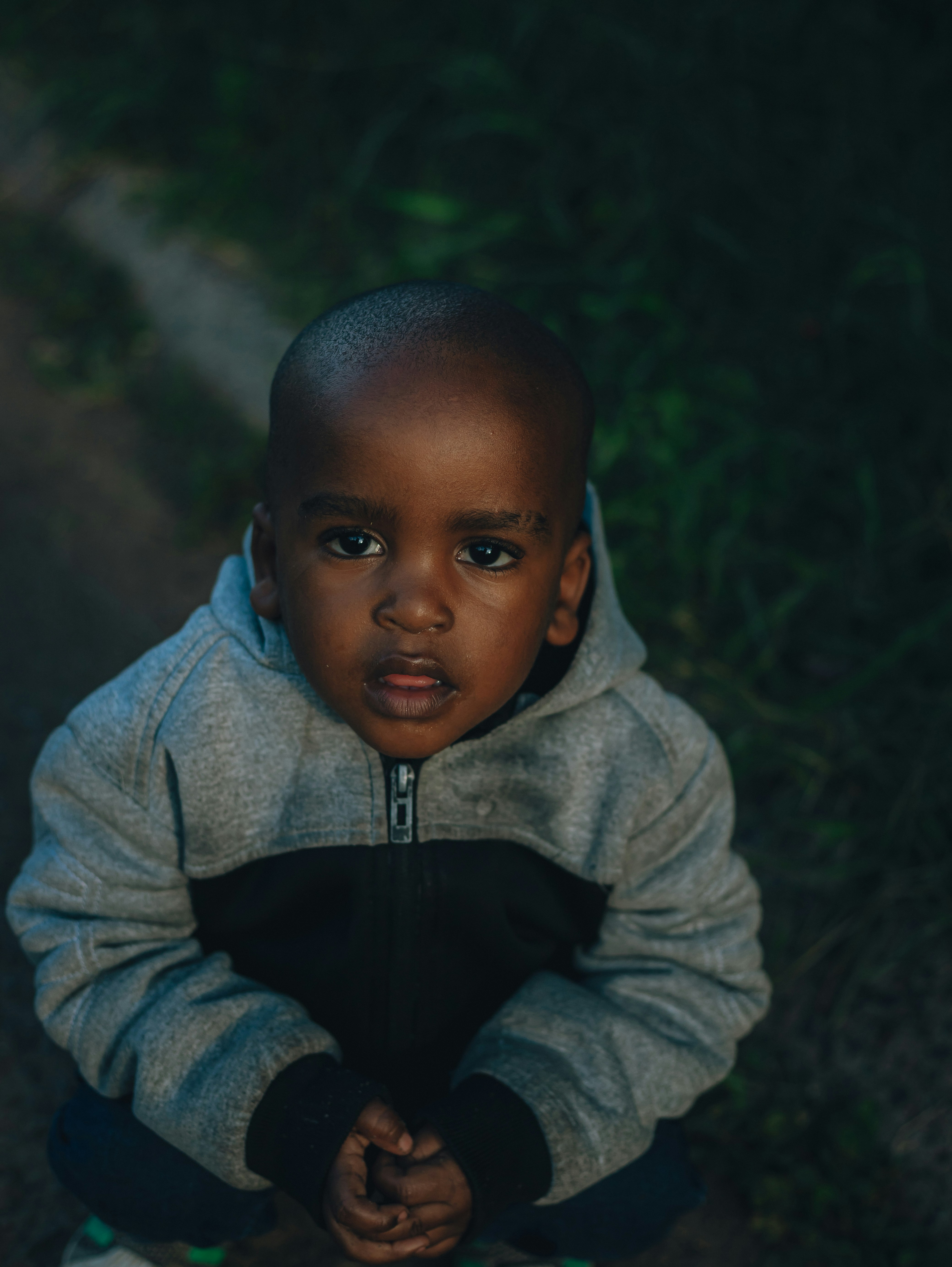 Close‑up of a curious toddler in a gray hoodie