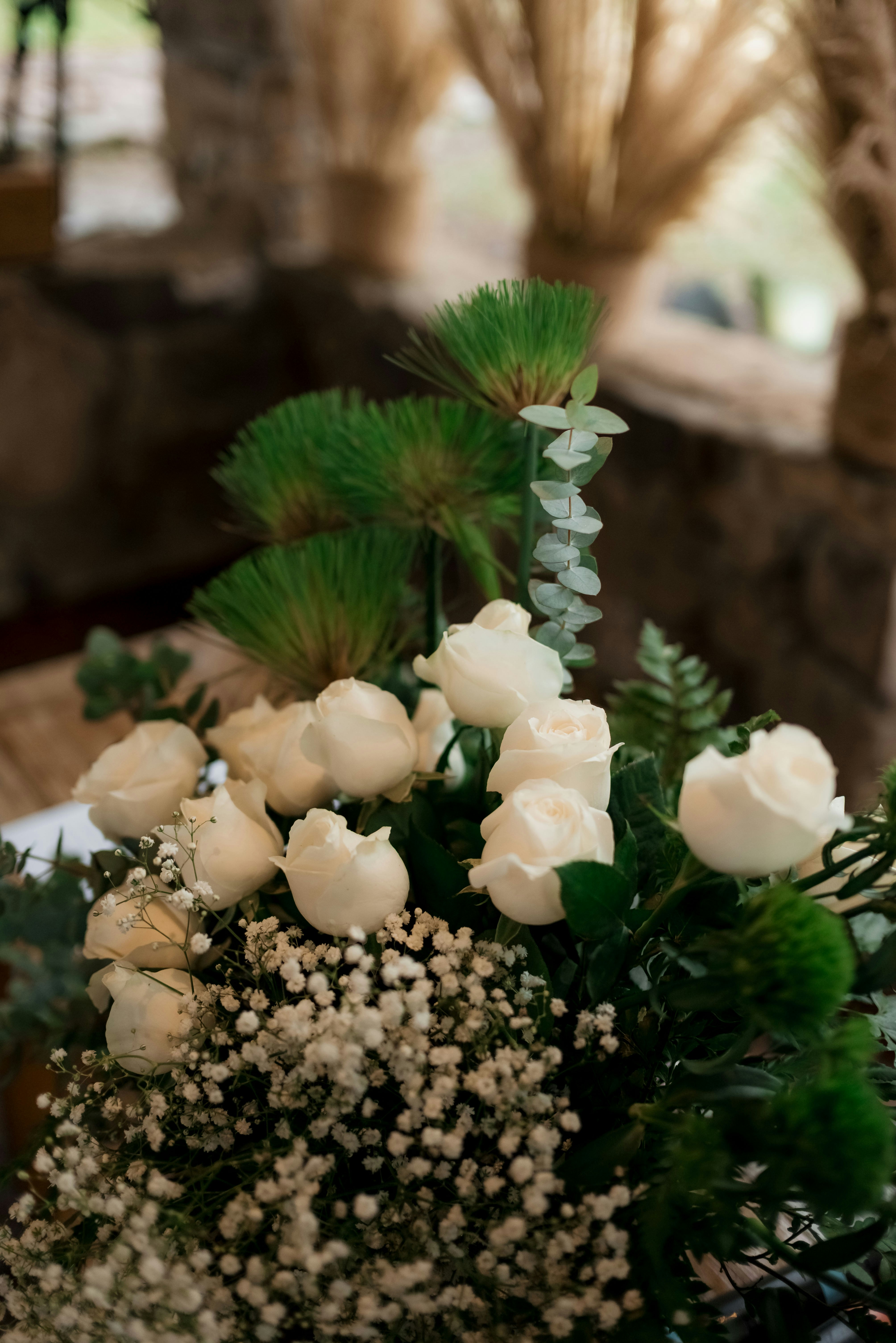 Elegant white roses with baby's breath and green leaves.
