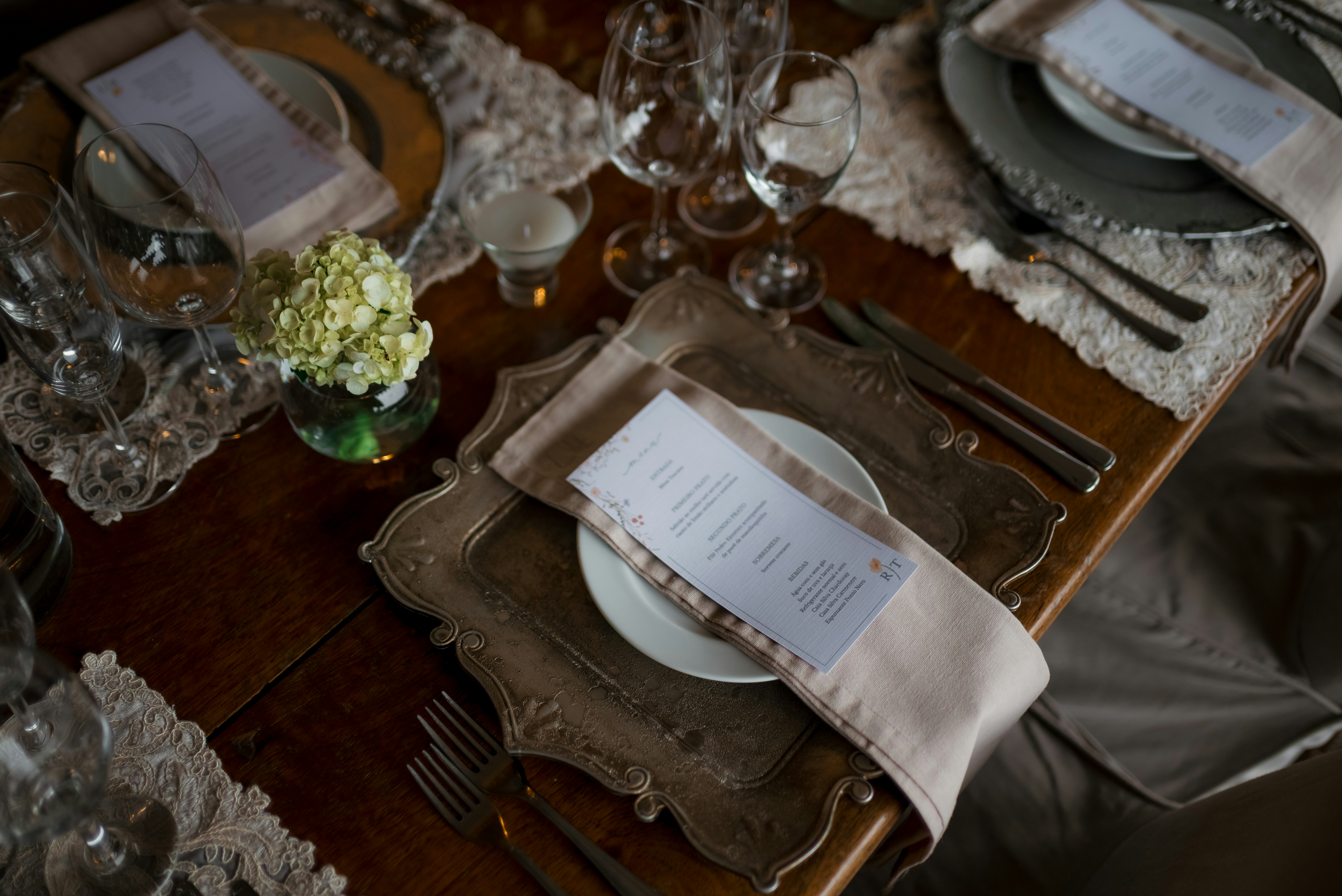 Elegant dining table set with plates, glasses, and floral centerpiece.