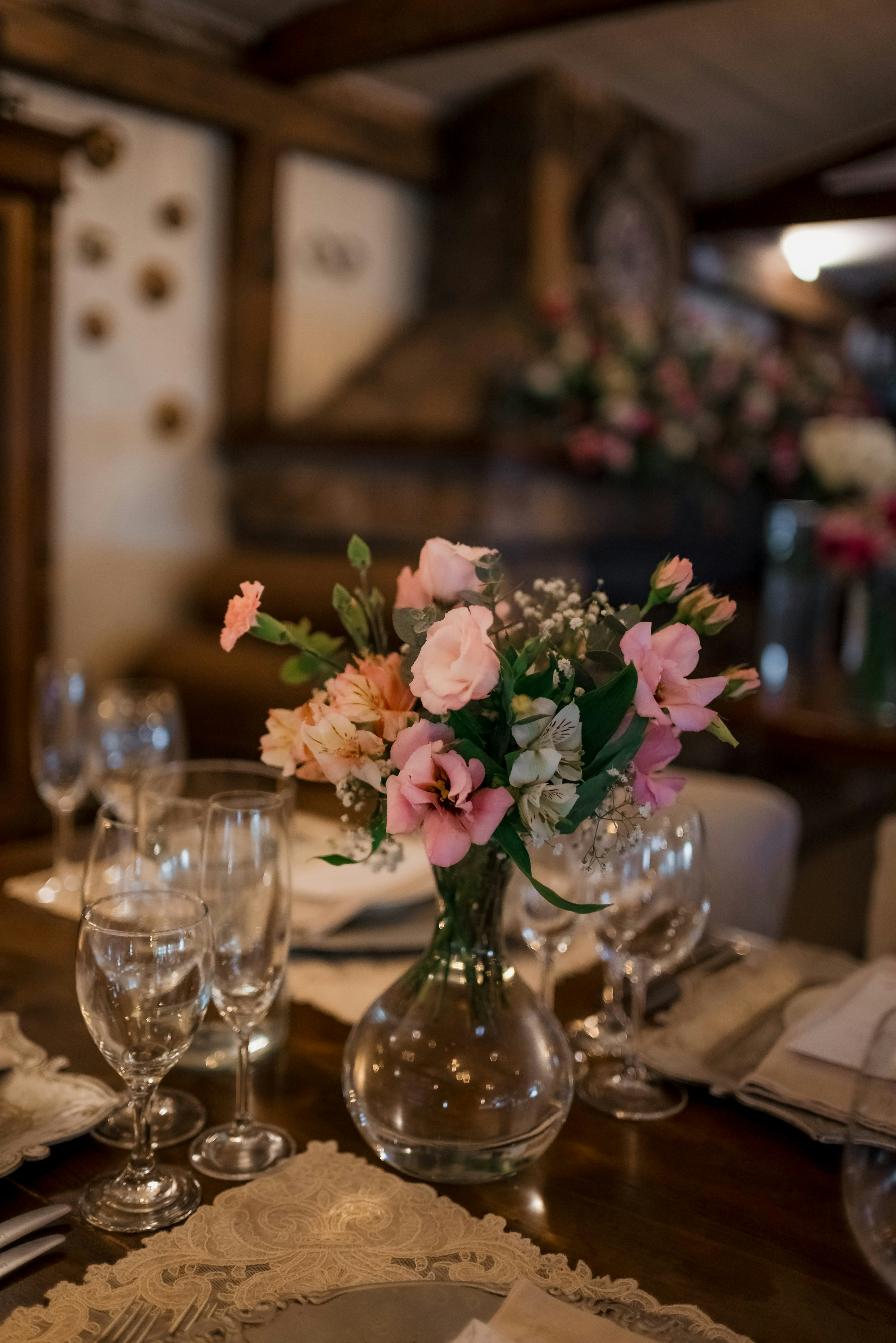 Elegant table setting with pink flowers and crystal glasses.