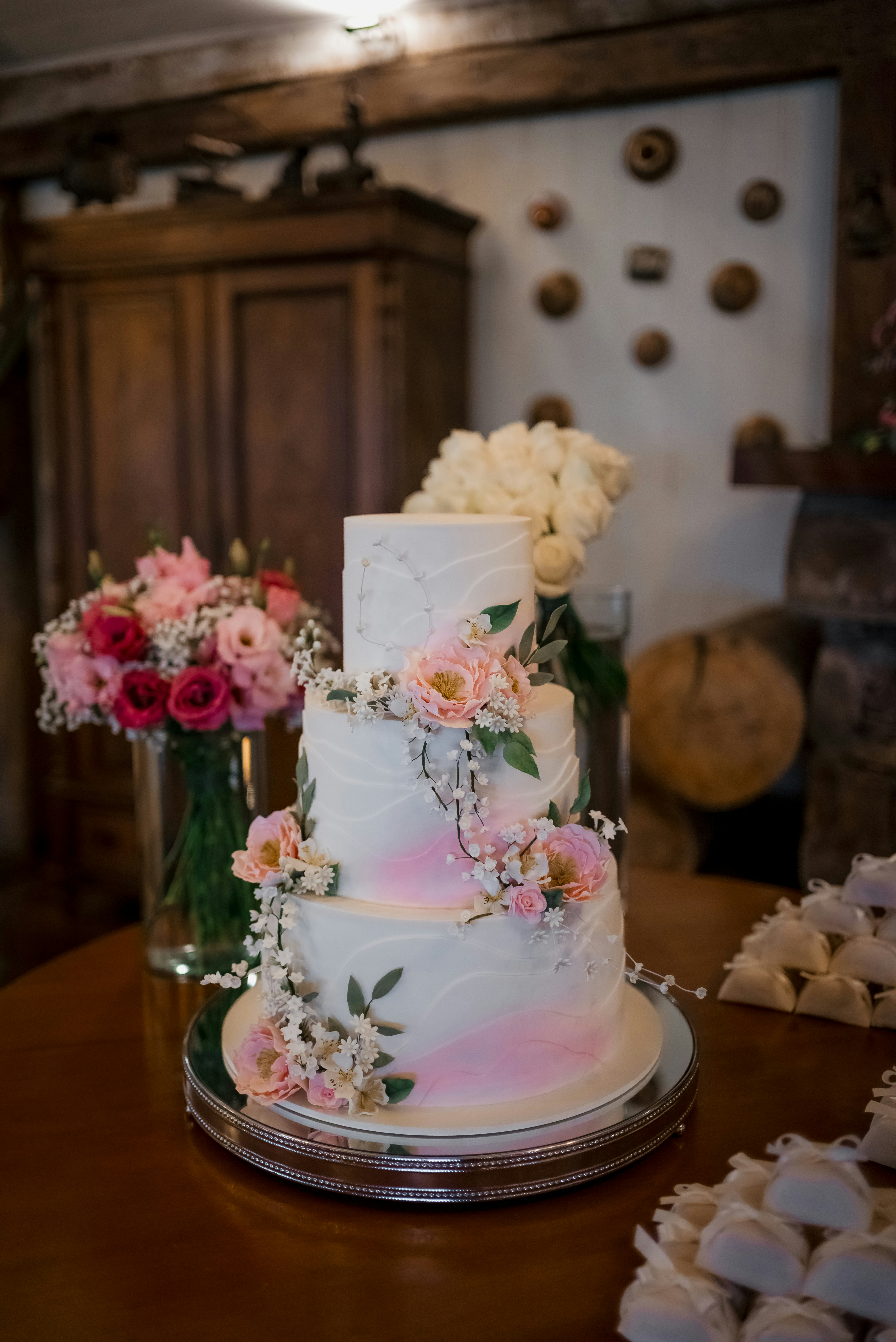 Petal Cascade: a pastel wedding cake centerpiece in a rustic reception