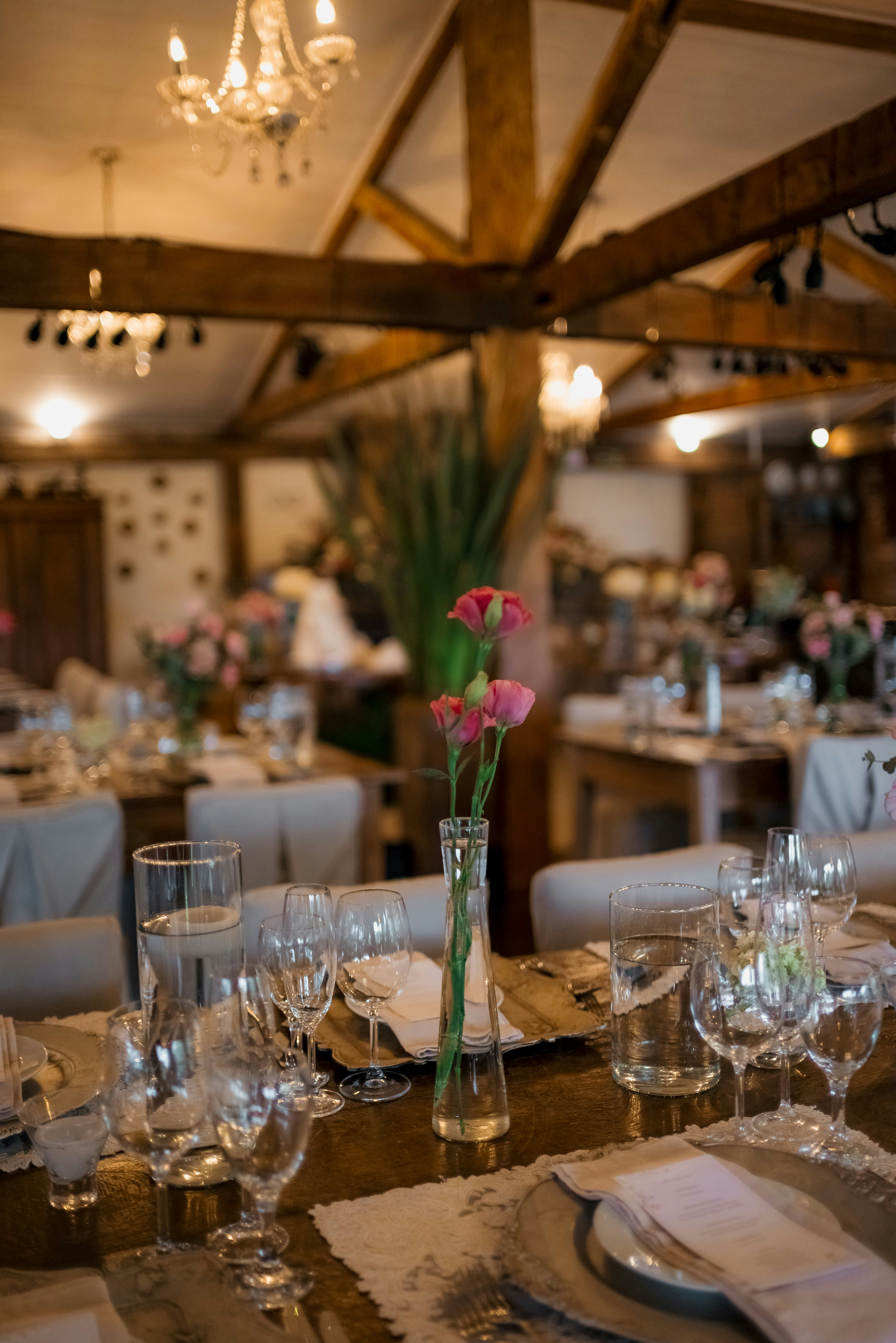Elegant table setting with pink flowers in a rustic venue.