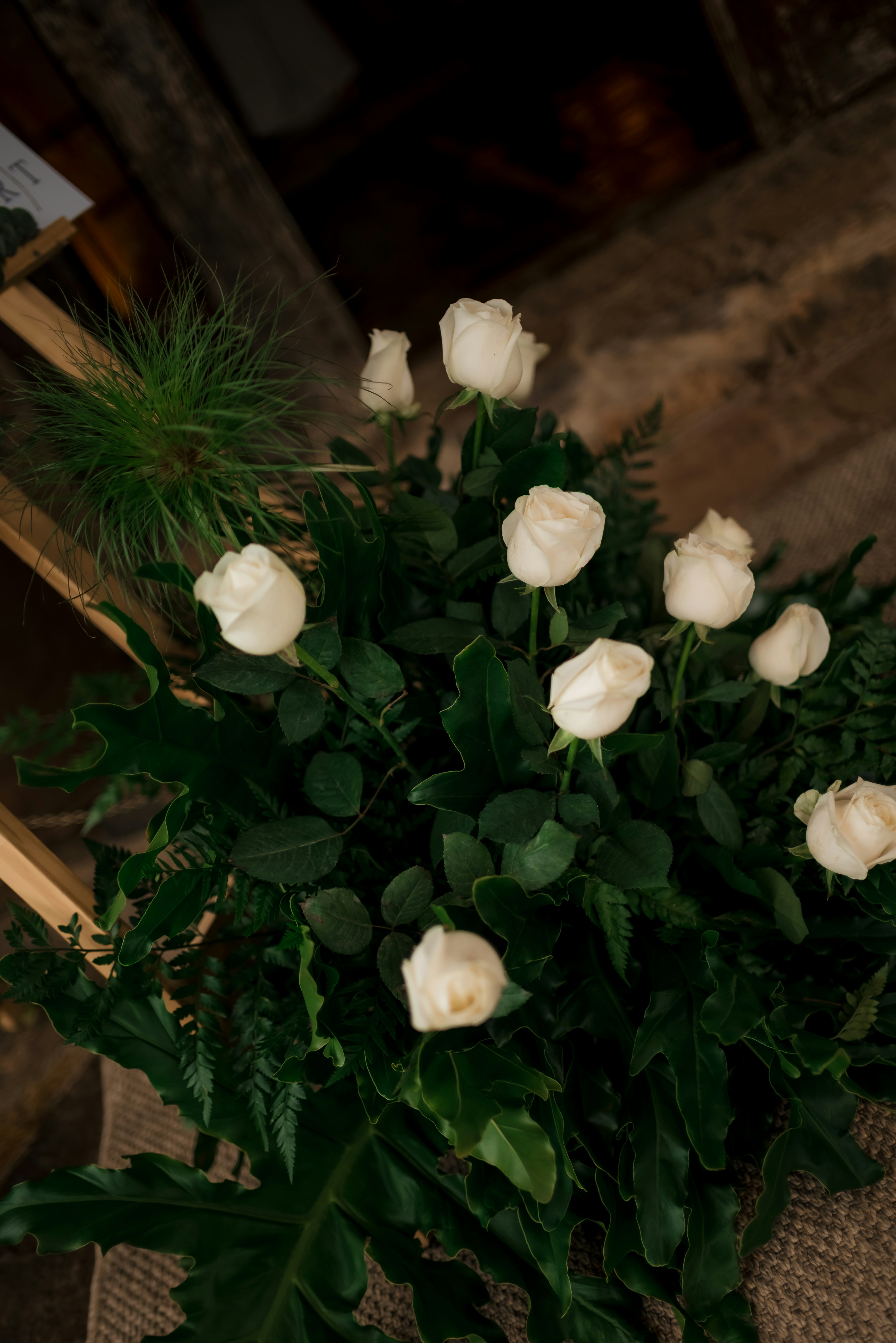 White Rose Mosaic: A Quiet Bouquet Amid Dark Wood and Greenery