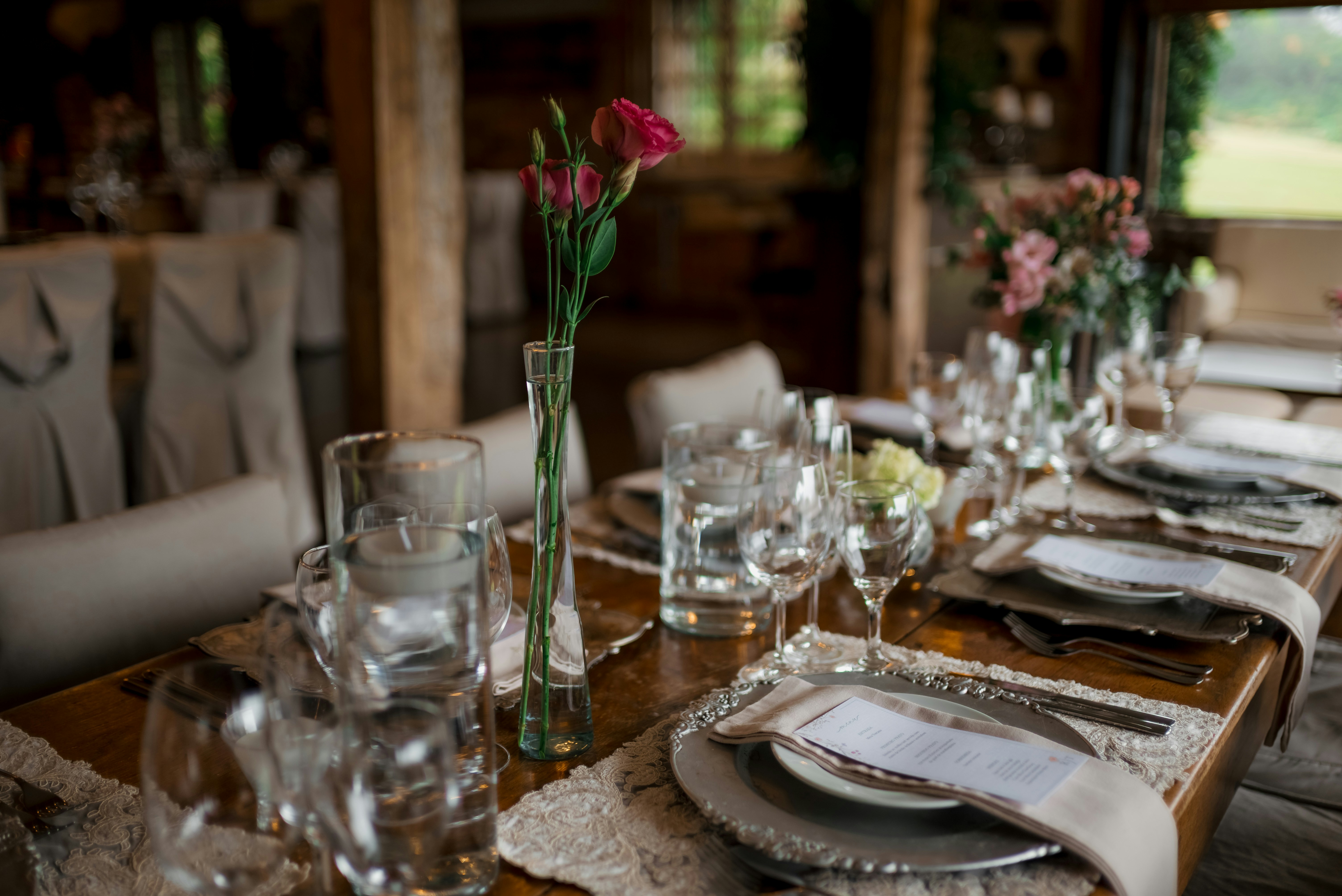 Elegant dining table set with flowers, glasses, and plates.