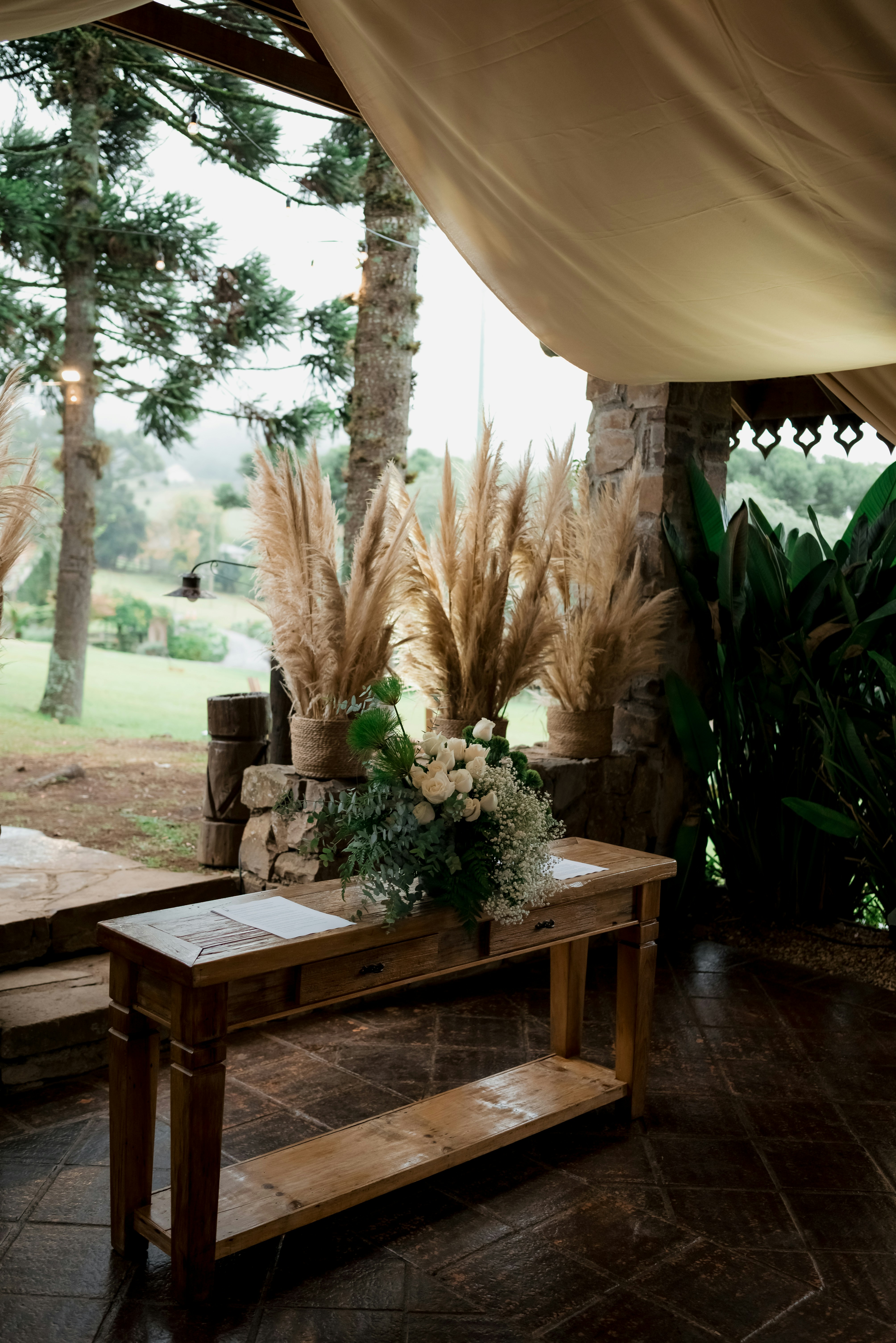 Floral Arrangement on a Rustic Aisle Table Under a Canopy