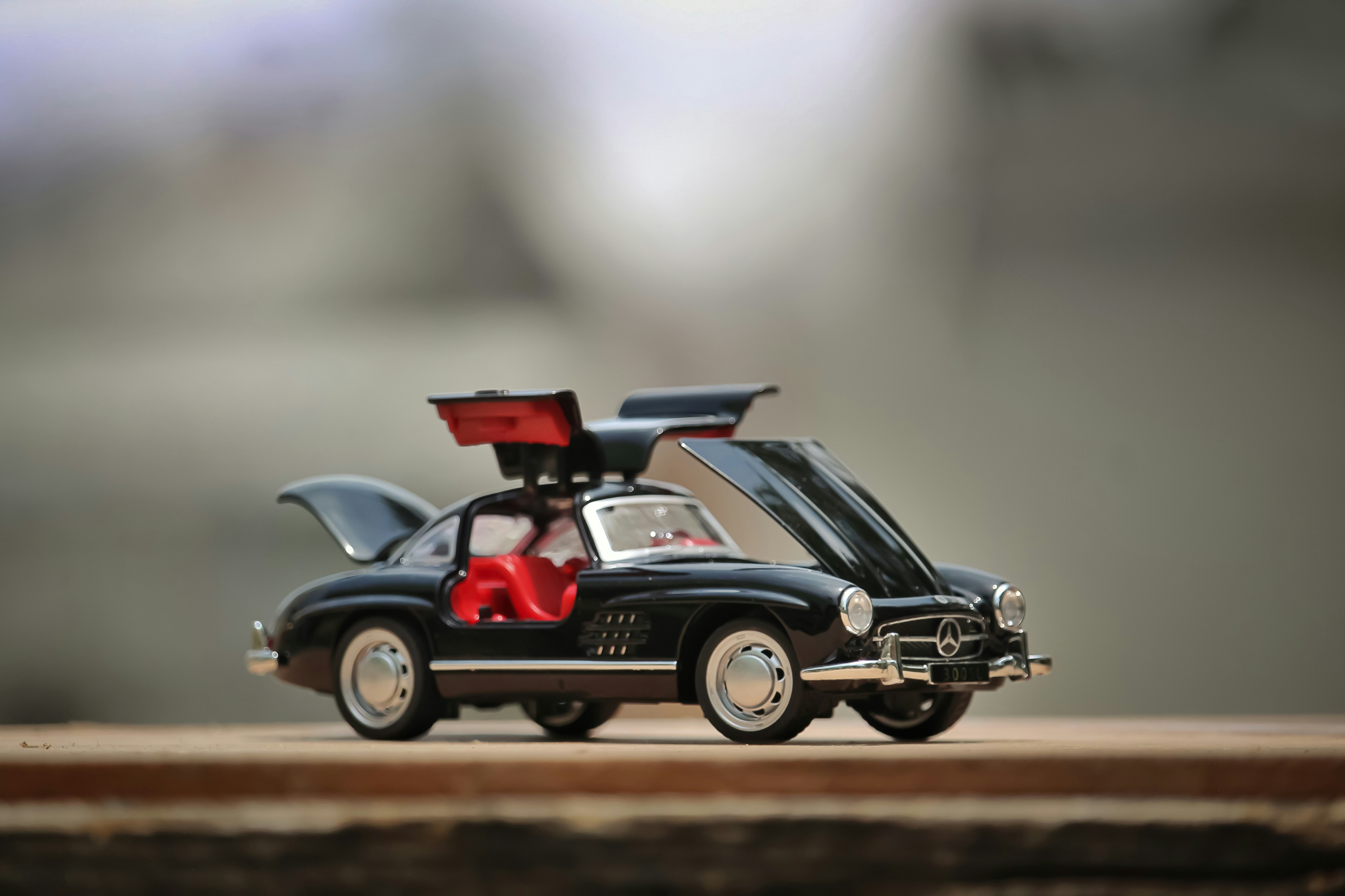 Miniature Mercedes in Focus: A Classic Toy Car on a Wooden Stage